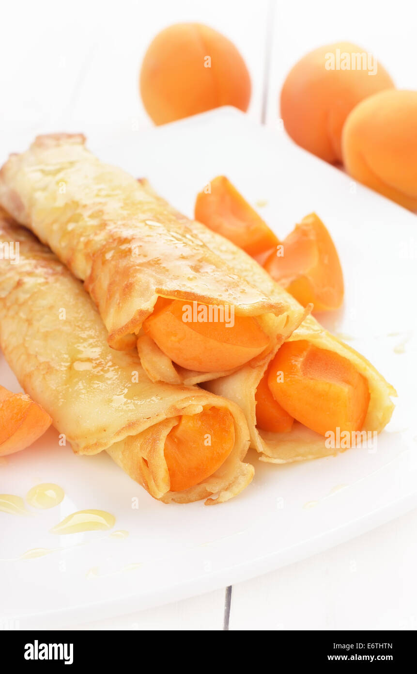 Crepes with apricot slices on white plate Stock Photo - Alamy
