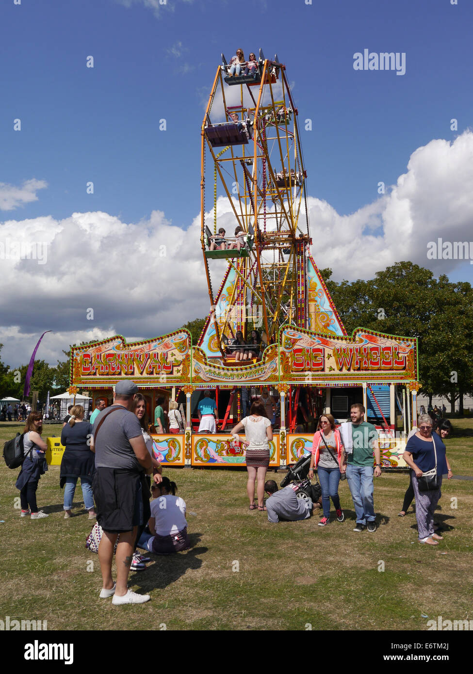 People riding a ferris wheel at a funfair Stock Photo - Alamy