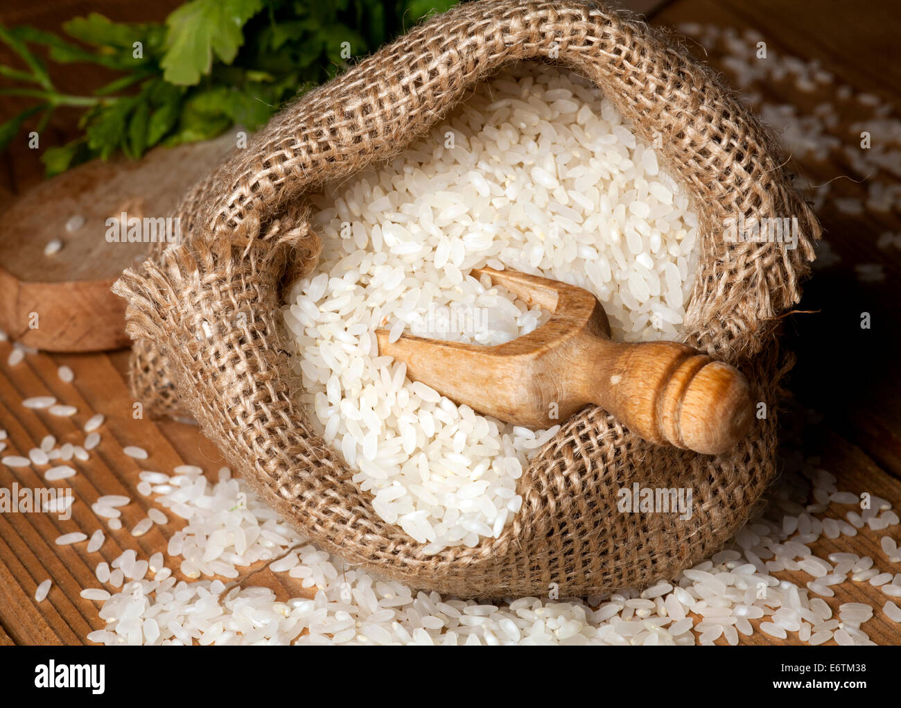 White rice in a sack and wooden scoops on wooden background Stock Photo ...
