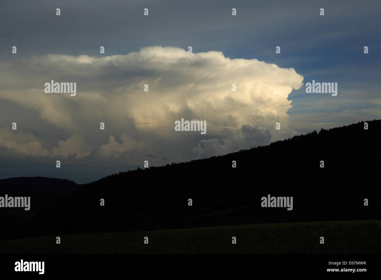 A photograph of some cumulus storm clouds building over a darkened ...