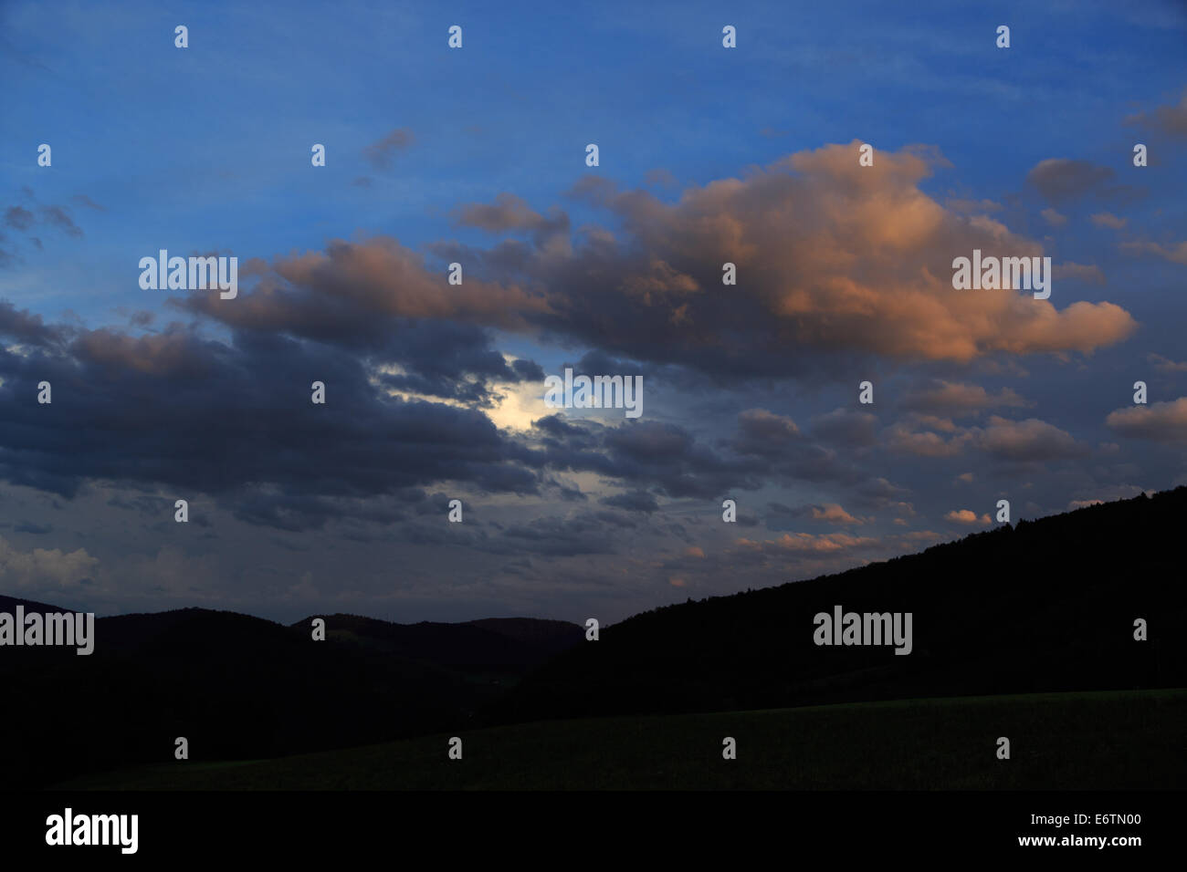A photograph of the moon showing in the distance between some dark and ...