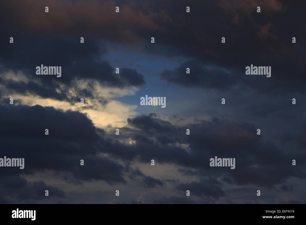 A photograph of the moon showing between some dark and ominous storm ...