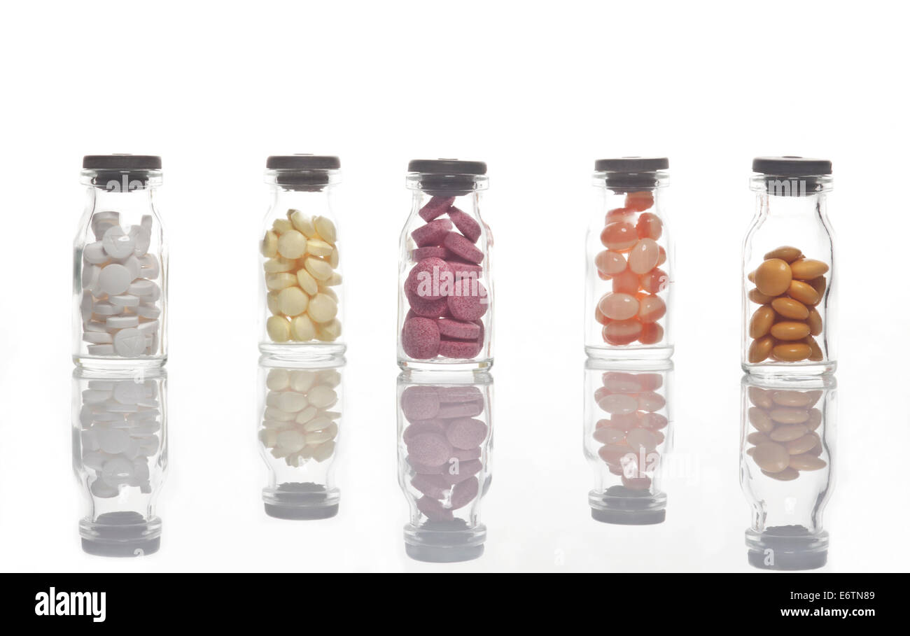 Pills in different colors in glass medicine vials Stock Photo - Alamy