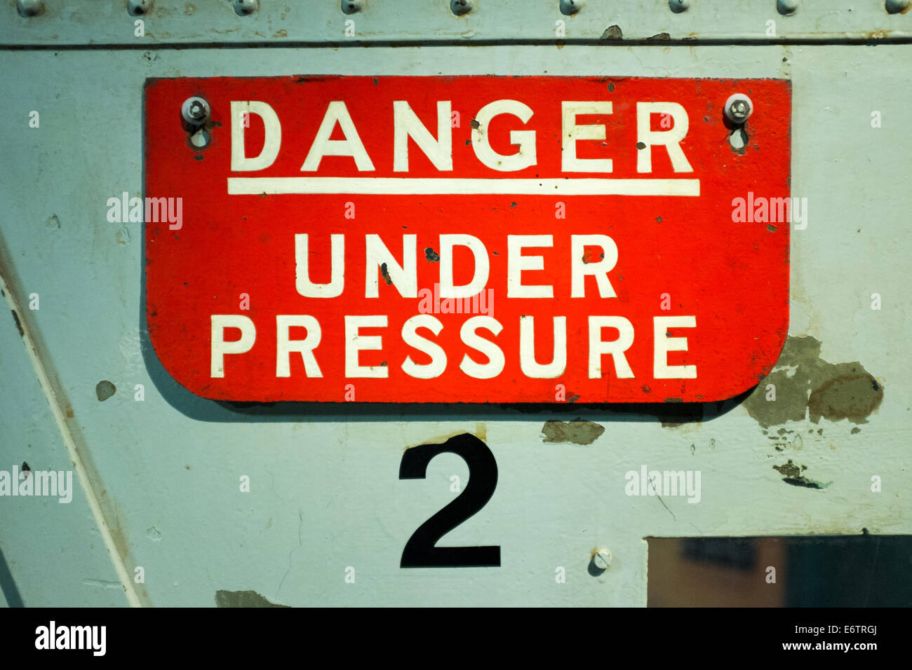 Red "Danger under pressure" sign from a factory Stock Photo - Alamy
