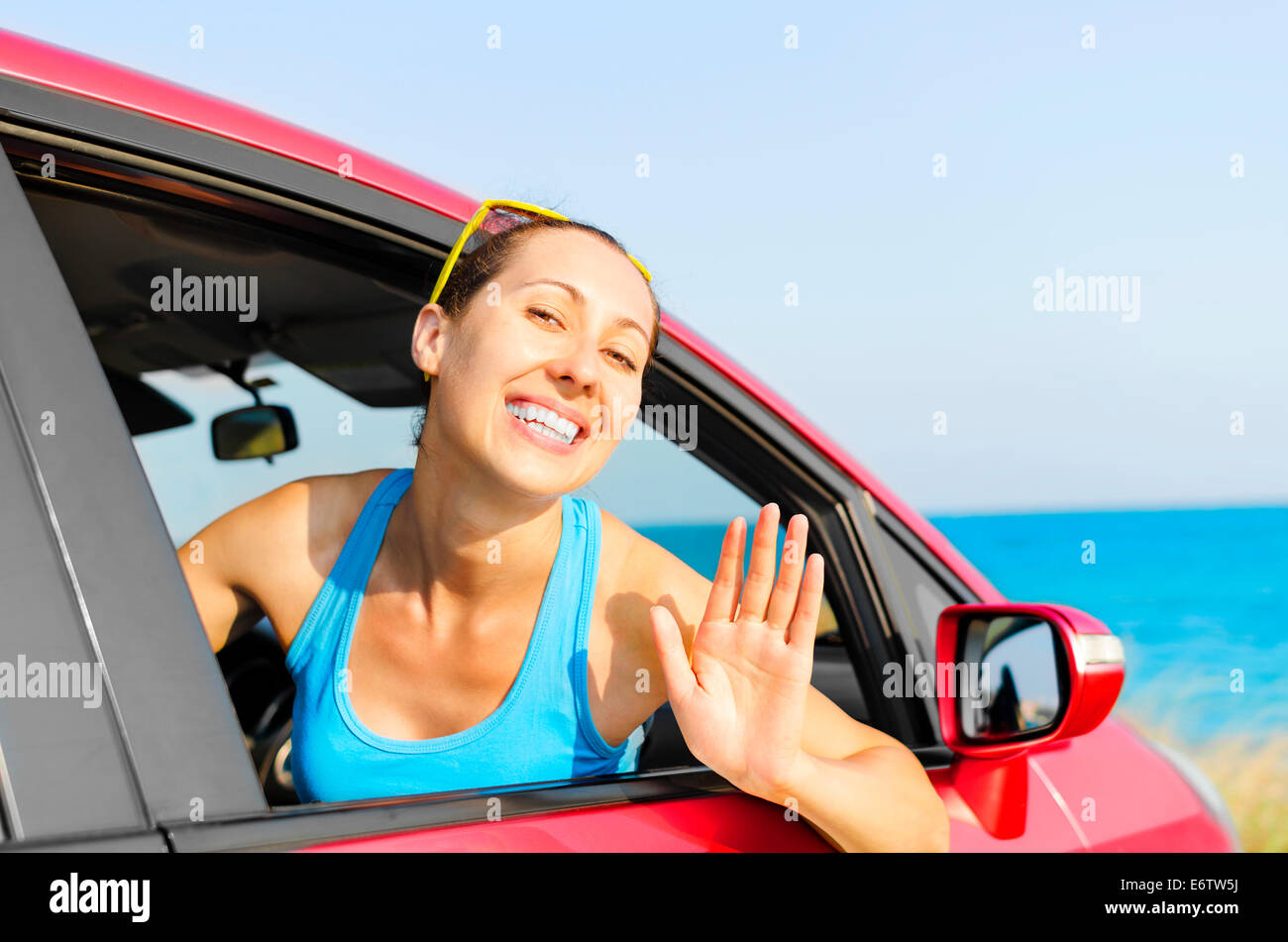 Beautiful girl in a car smiling on a background of blue sea Stock Photo ...