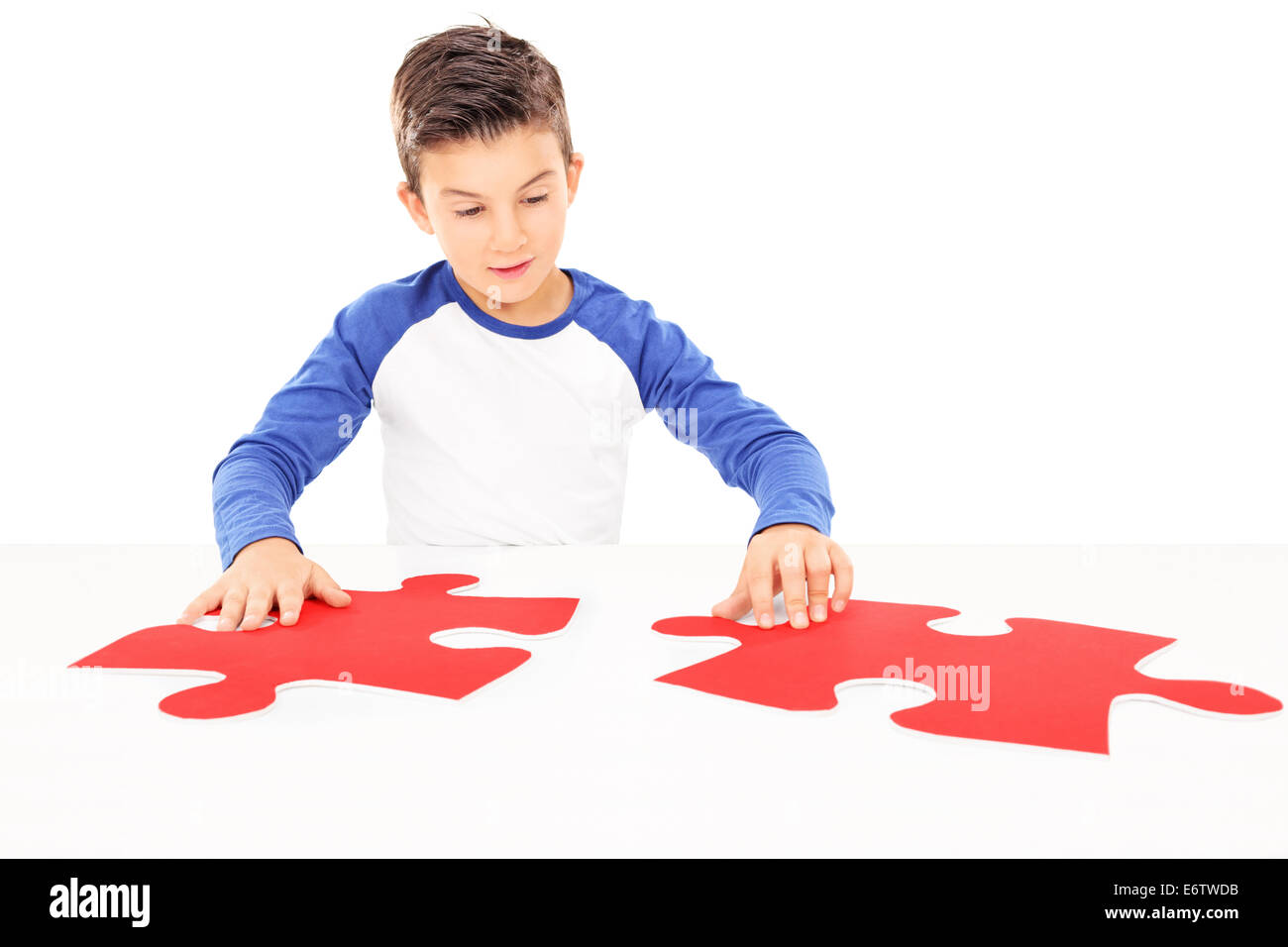 Boy connecting two huge pieces of a puzzle Stock Photo - Alamy