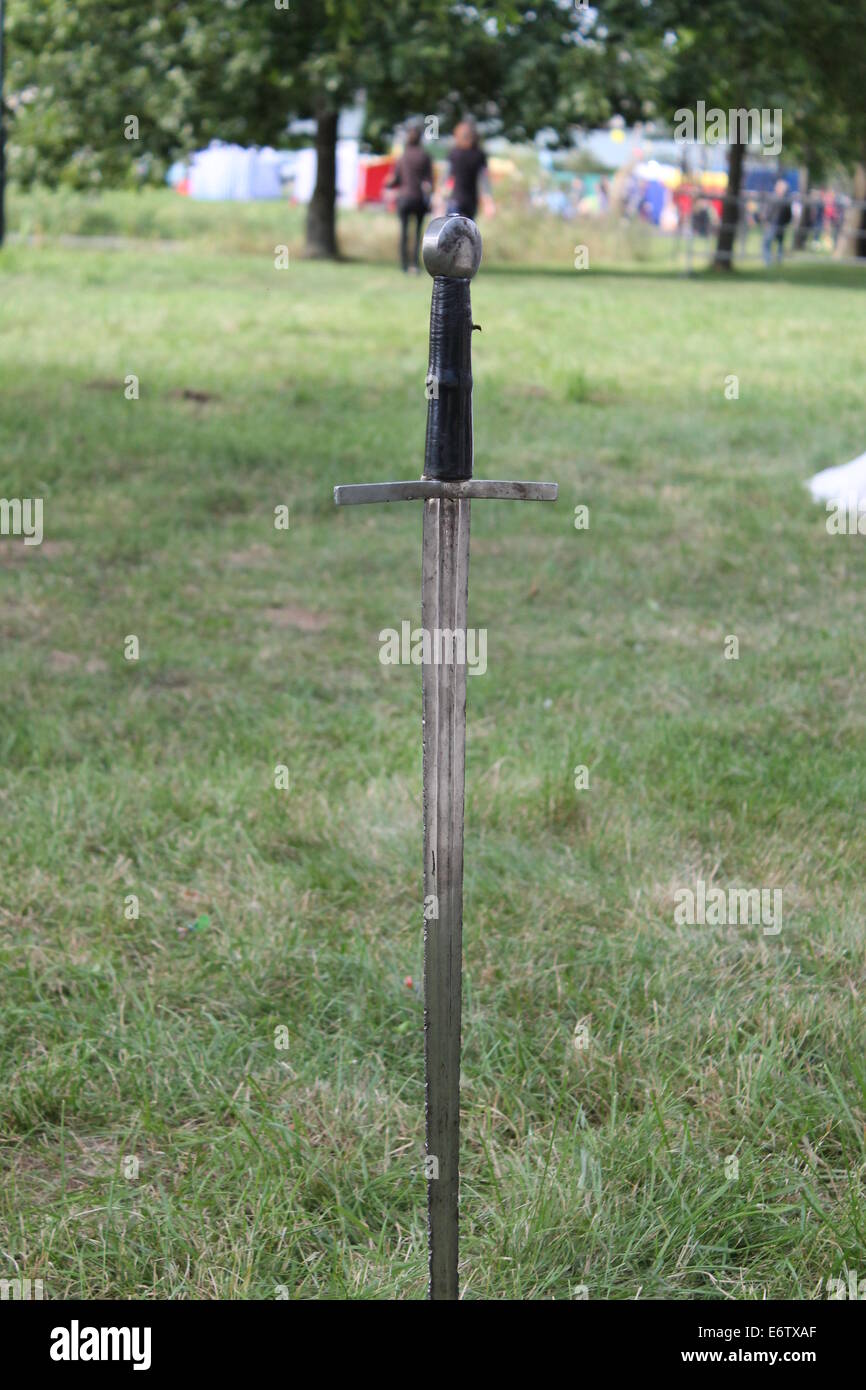 steel sharp shine real ancient sword stick in land covering green grass ...