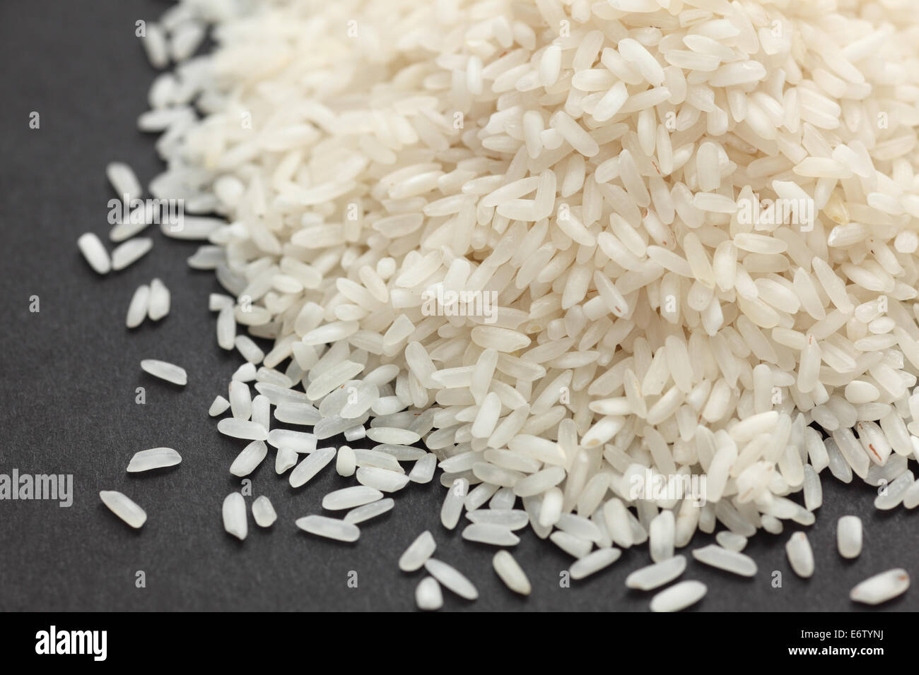 Rice heap on a black background. Closeup Stock Photo - Alamy