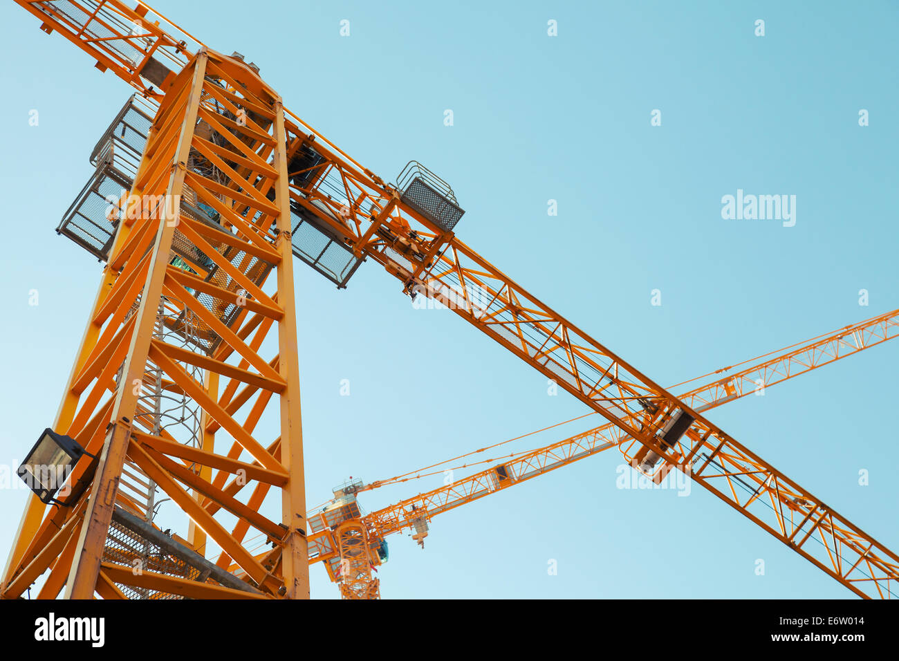 Modern yellow construction cranes above blue sky Stock Photo - Alamy