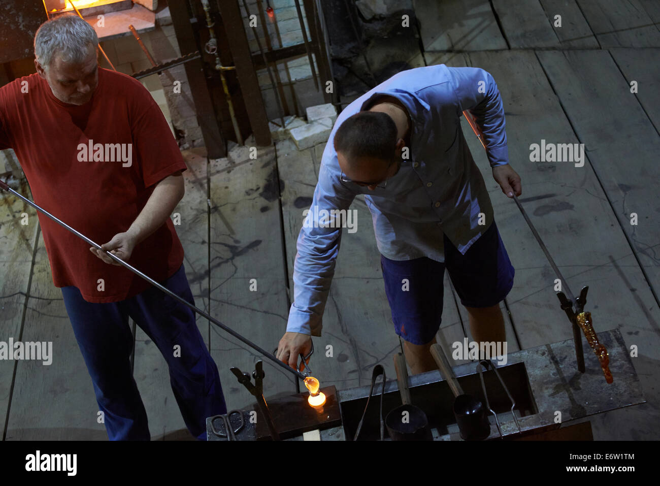 Glassmakers, Glassblowers forming molten glass, glass factory, Ajeto ...