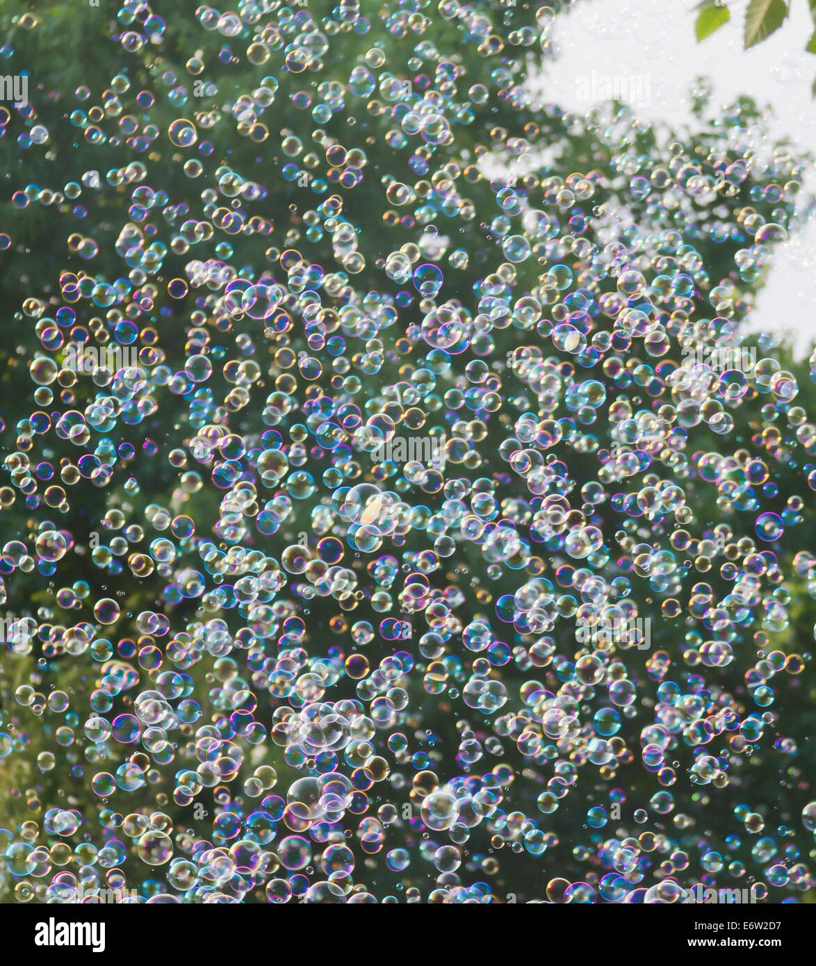 A mass of colorful, floating soap bubbles rising into the air together ...