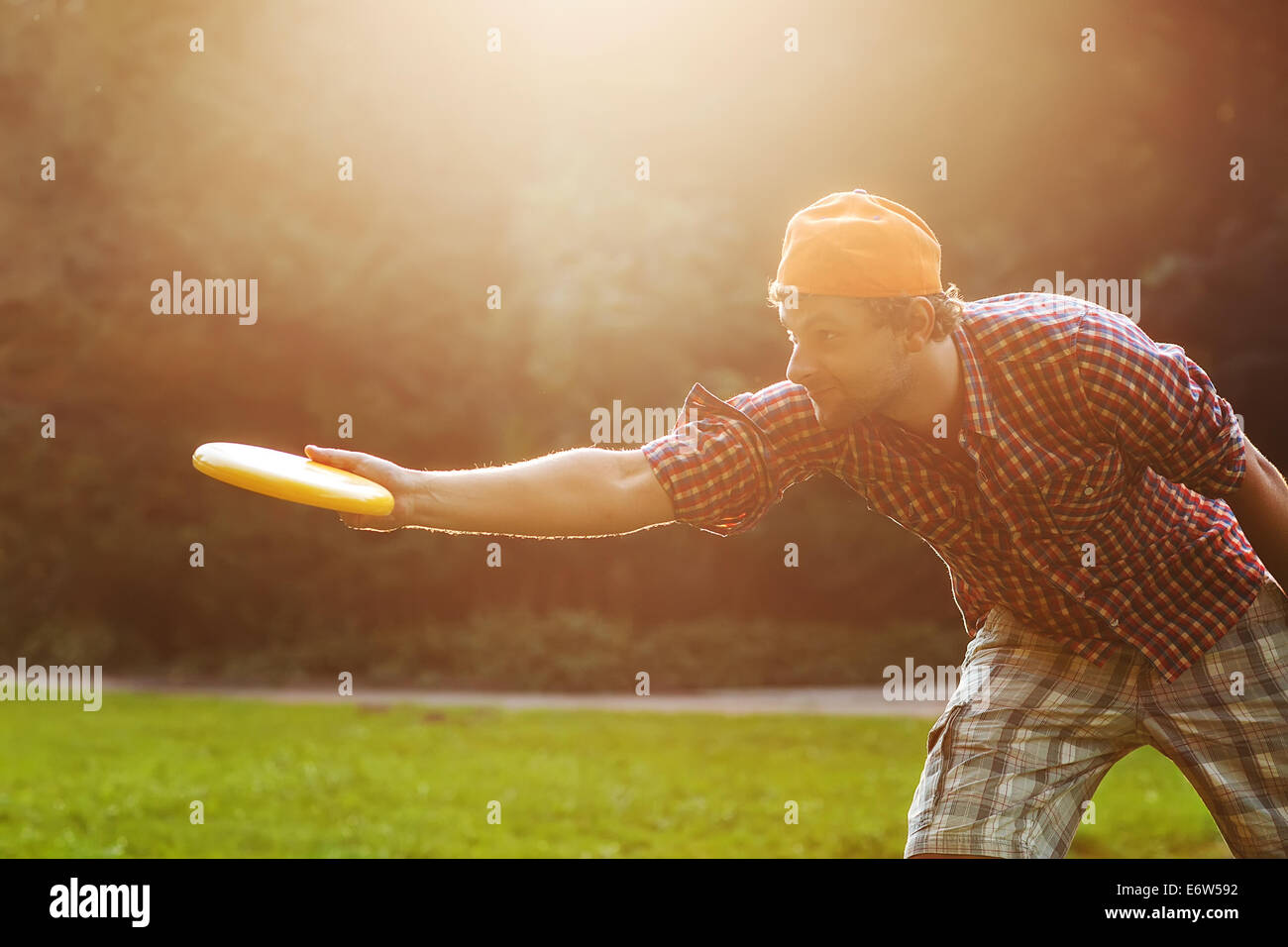 man playing in the park with a plate frisbee Stock Photo - Alamy