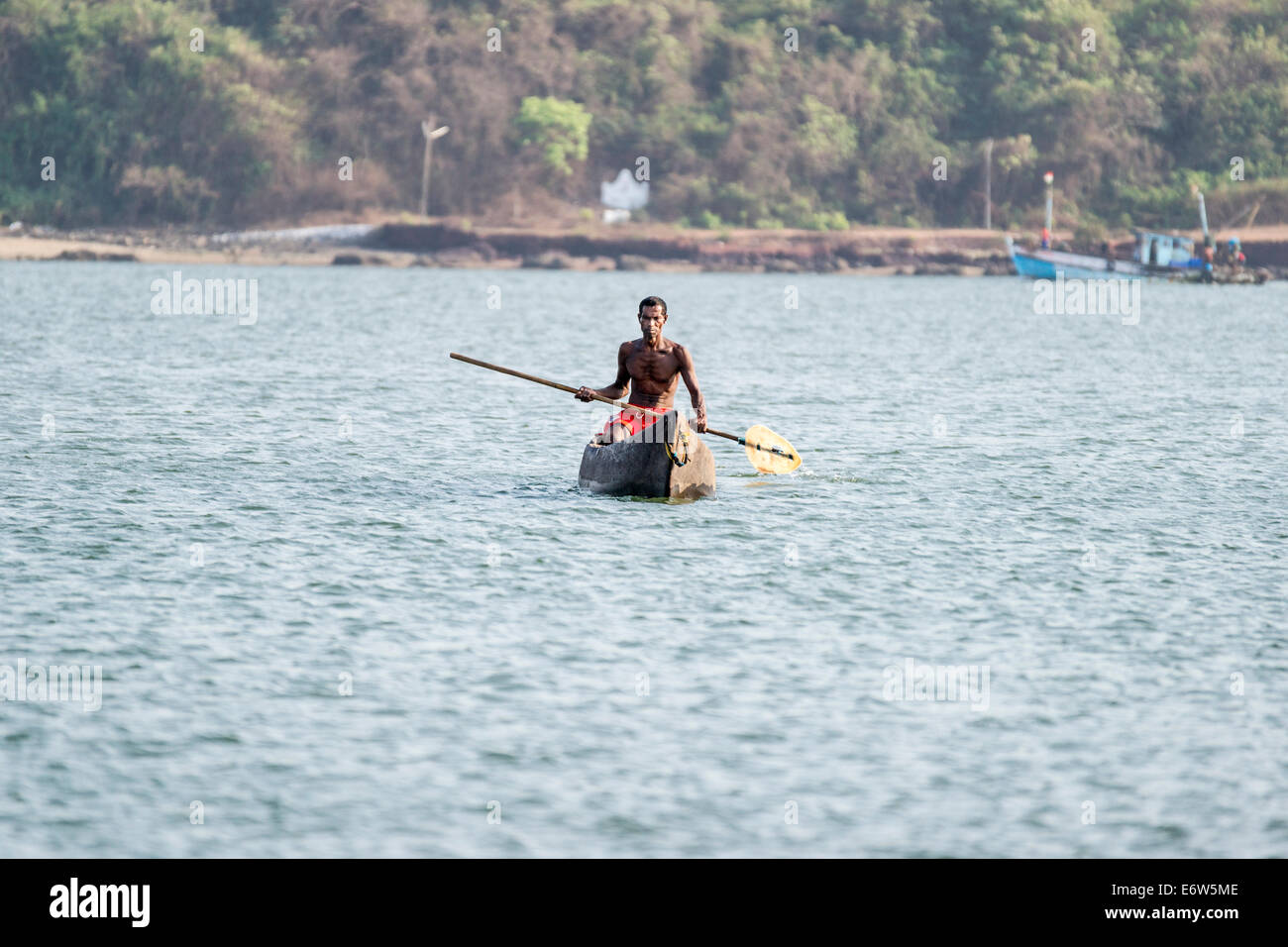 a man paddling an old canoe Stock Photo - Alamy
