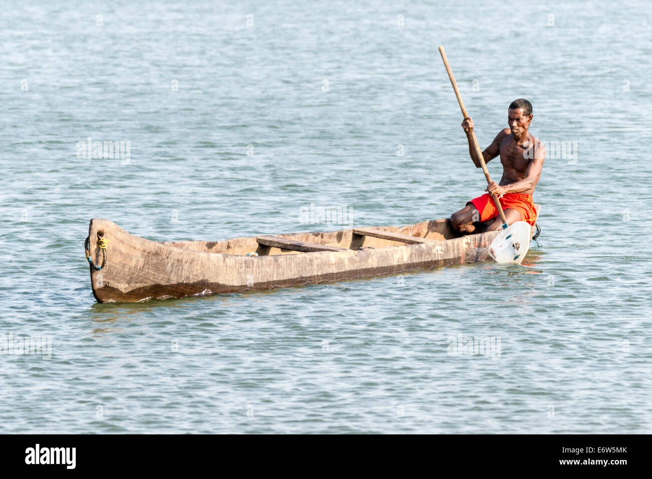 a man paddling an old canoe Stock Photo - Alamy