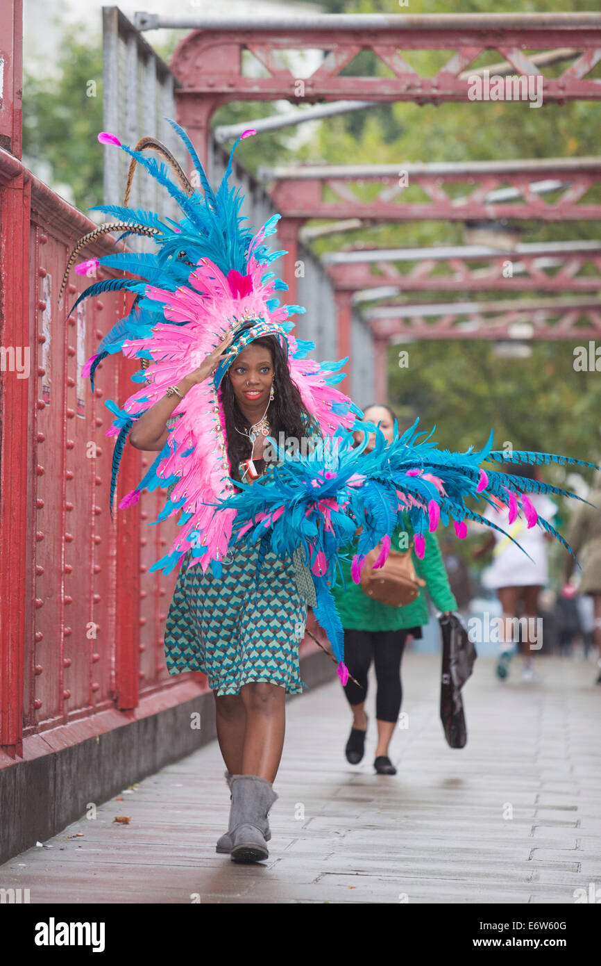 A performer carrying feathers makes her way to the parade at Notting ...