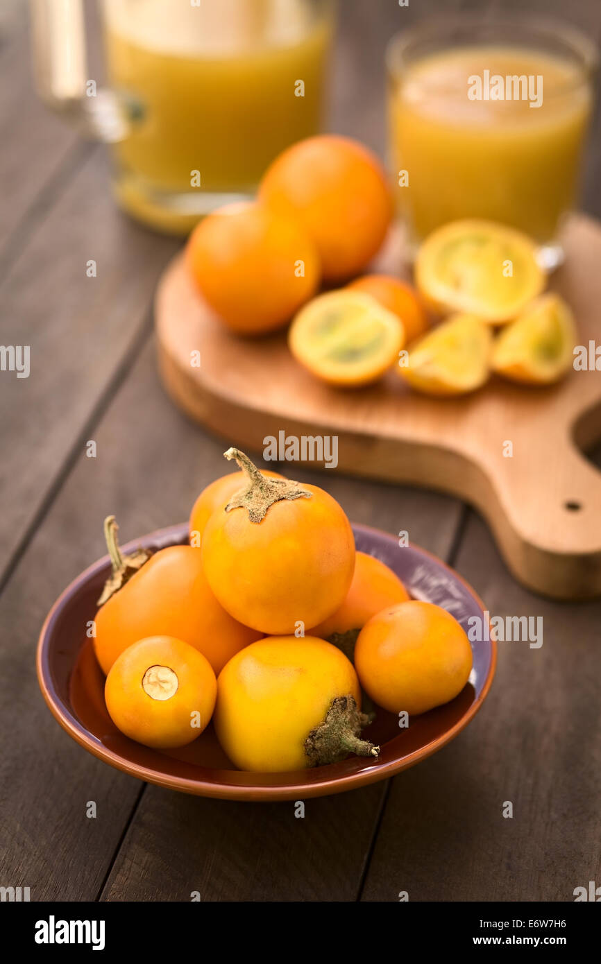 Naranjilla or Lulo fruits (lat. Solanum quitoense) in bowl with cut ...