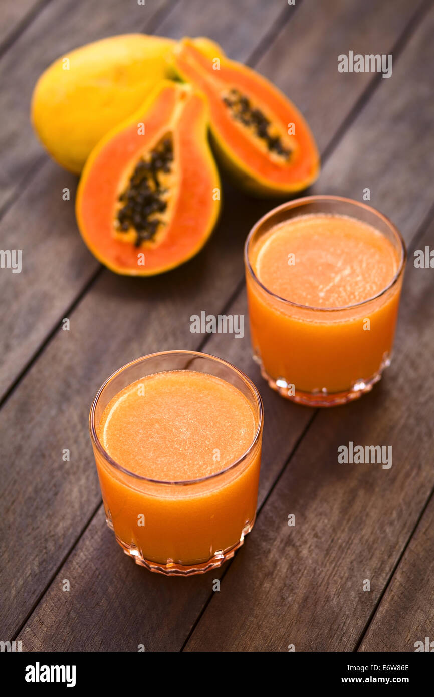 Two glasses of freshly prepared papaya juice with papaya fruits in the ...