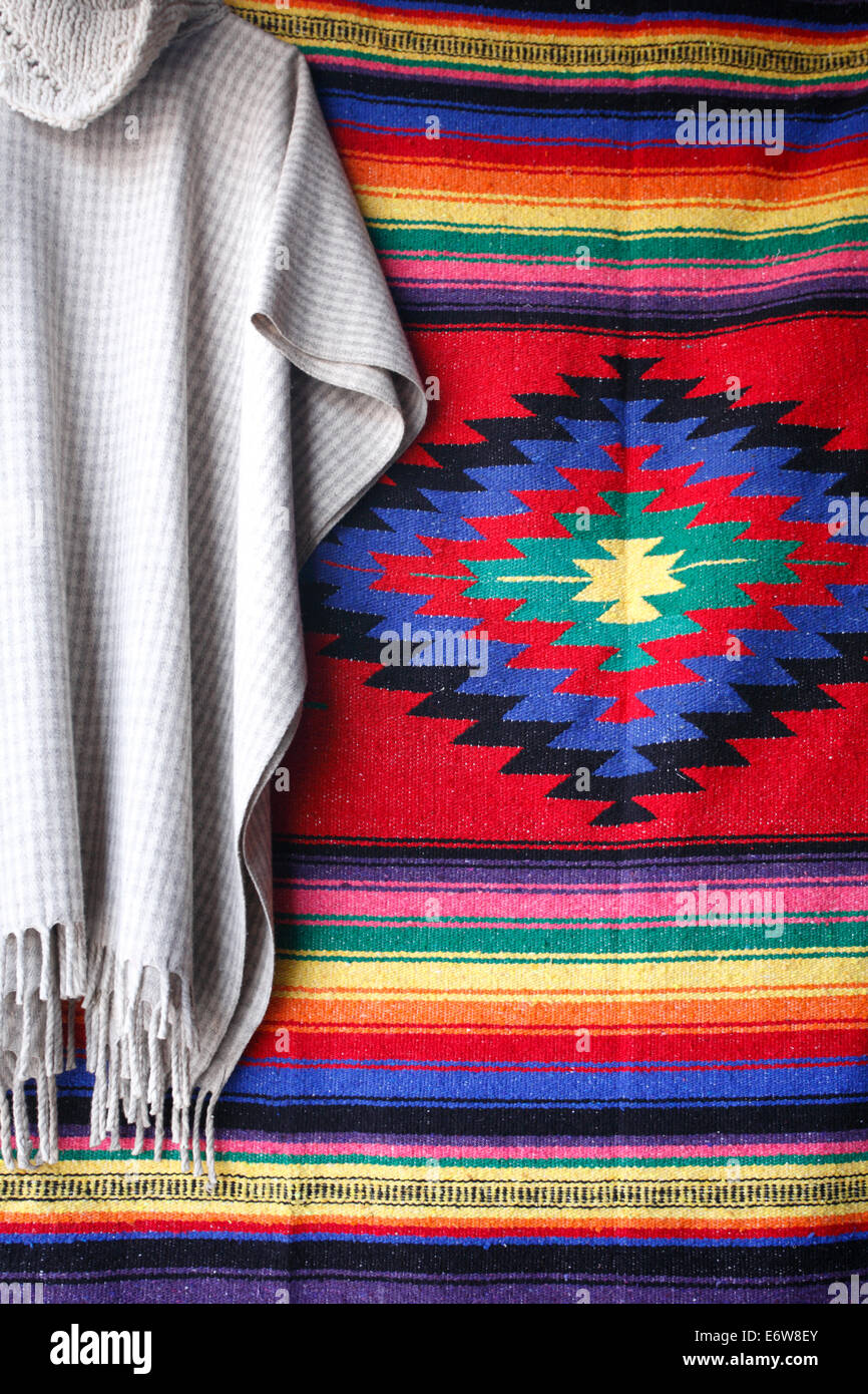 A poncho and colorful rug hand side by side in a Puebla, Mexico market ...