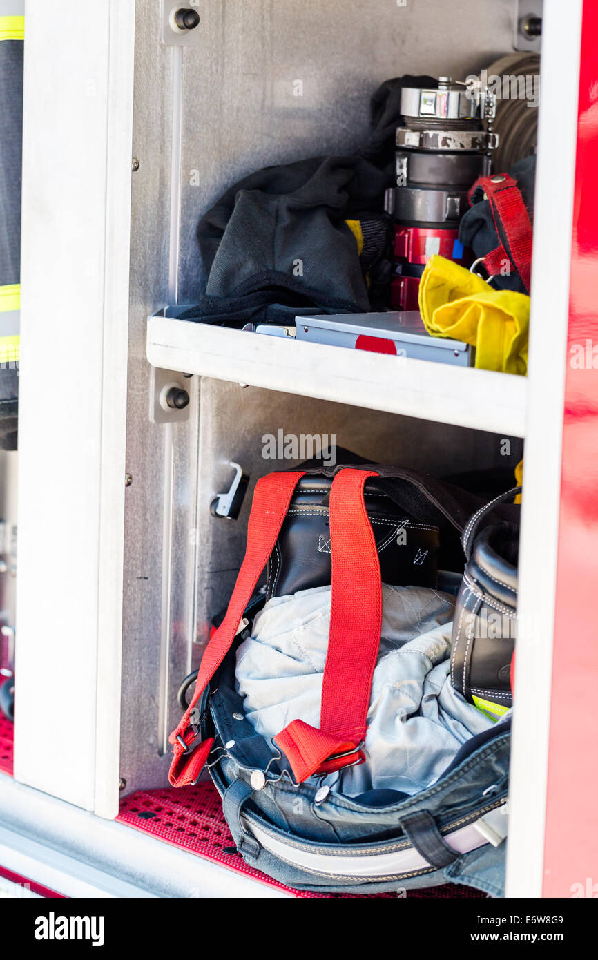 Firefighter clothing hanging on fire truck Stock Photo - Alamy