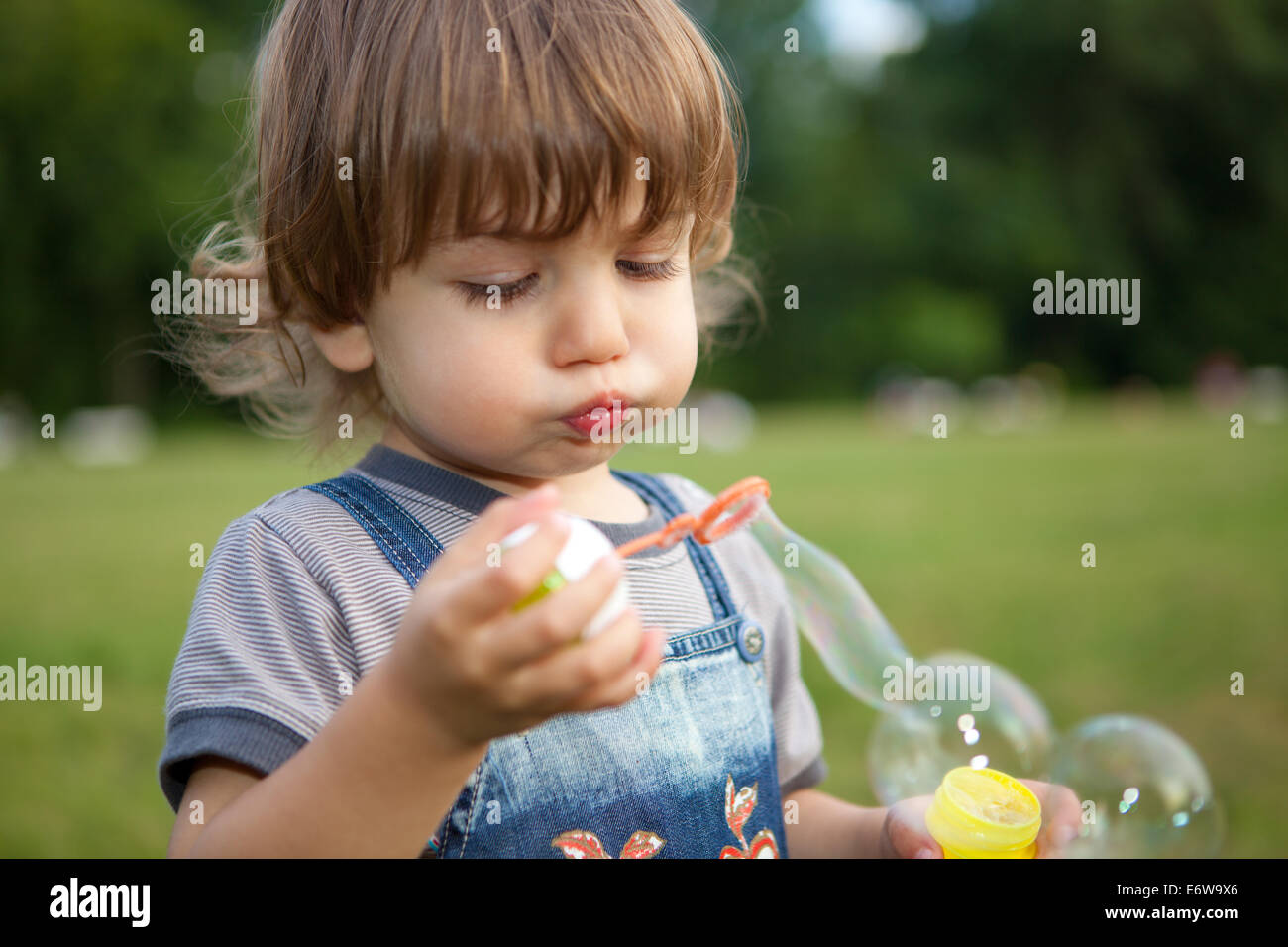 Little boy blowing soap bubbles in park Stock Photo - Alamy
