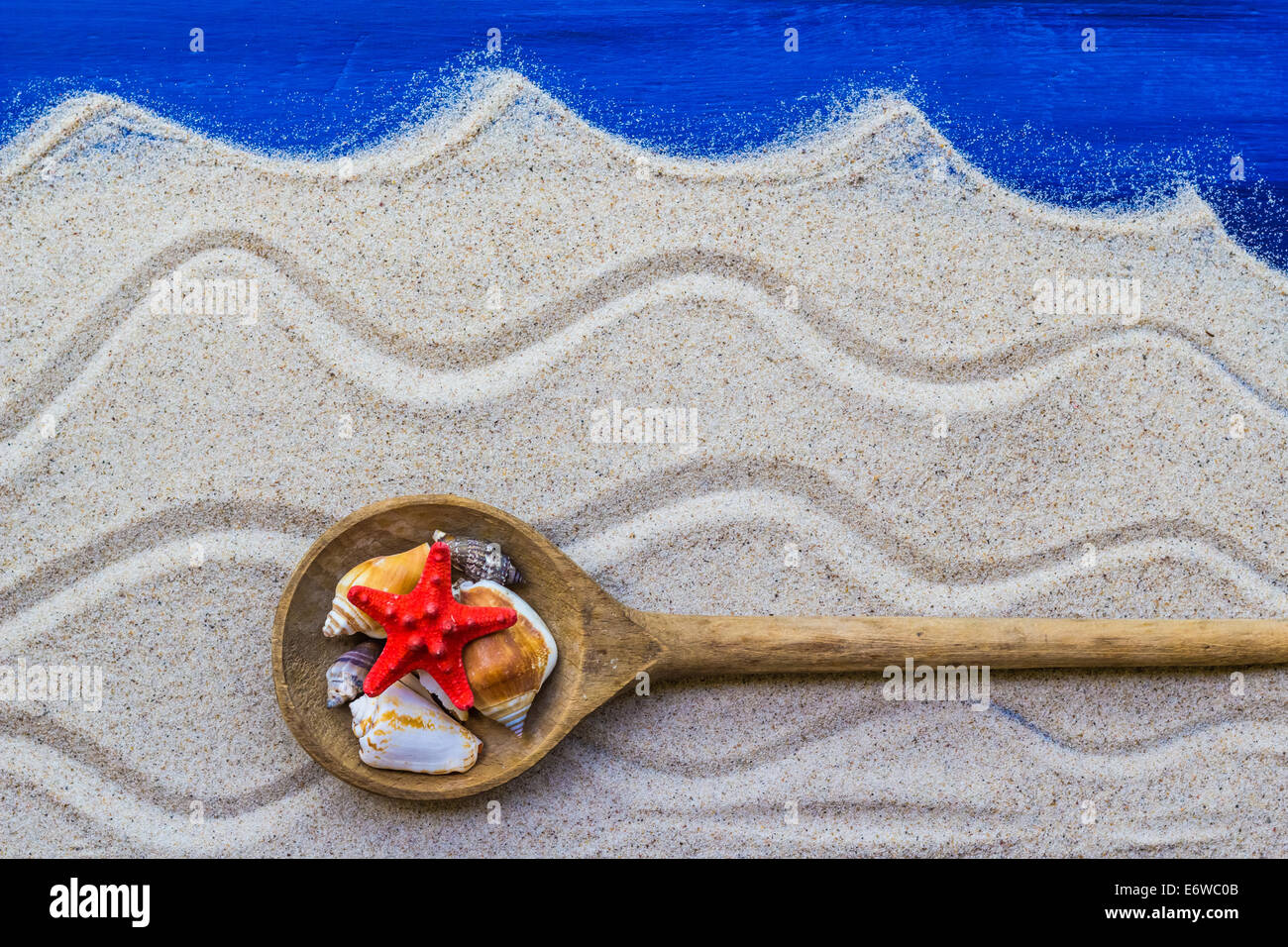Shells colored in a spoon on the beach sand Stock Photo - Alamy