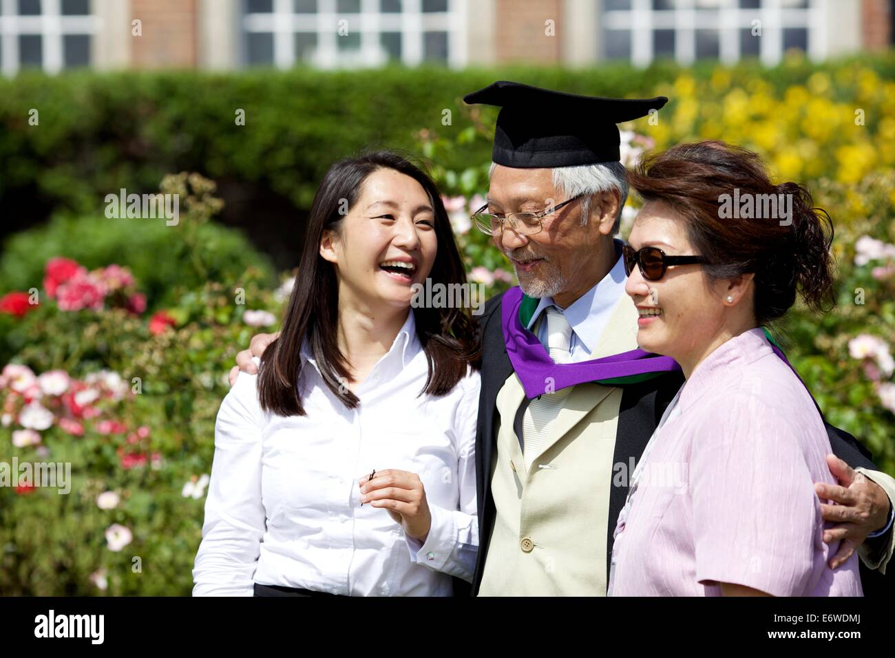 young asian female student at graduation ceremony with her parents ...