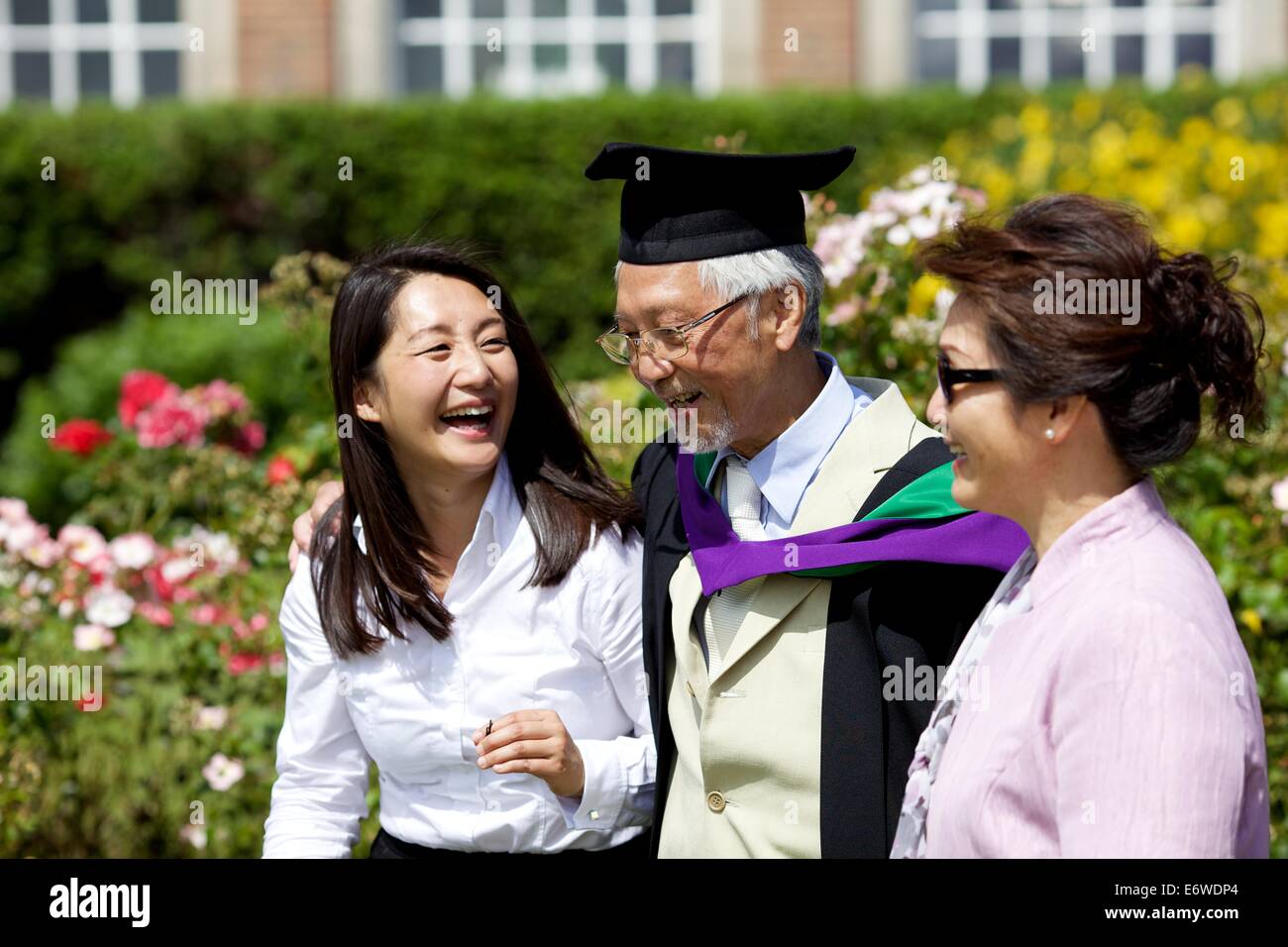 young asian female student at graduation ceremony with her parents ...