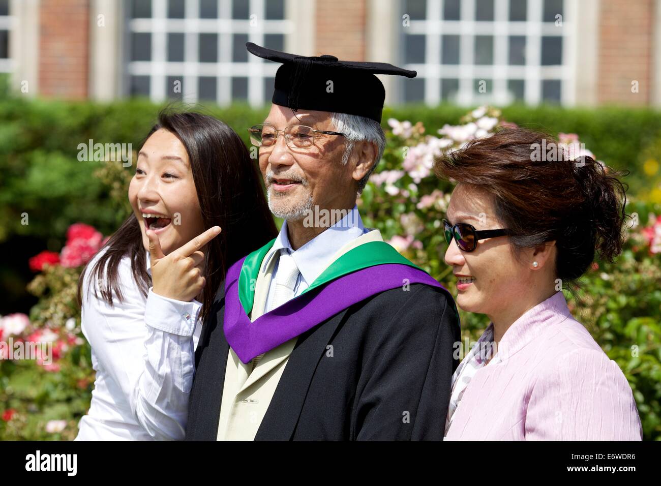 young asian female student at graduation ceremony with her parents ...