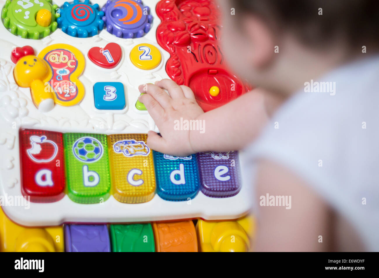 A baby boy playing with his multi-coloured baby walker Stock Photo - Alamy