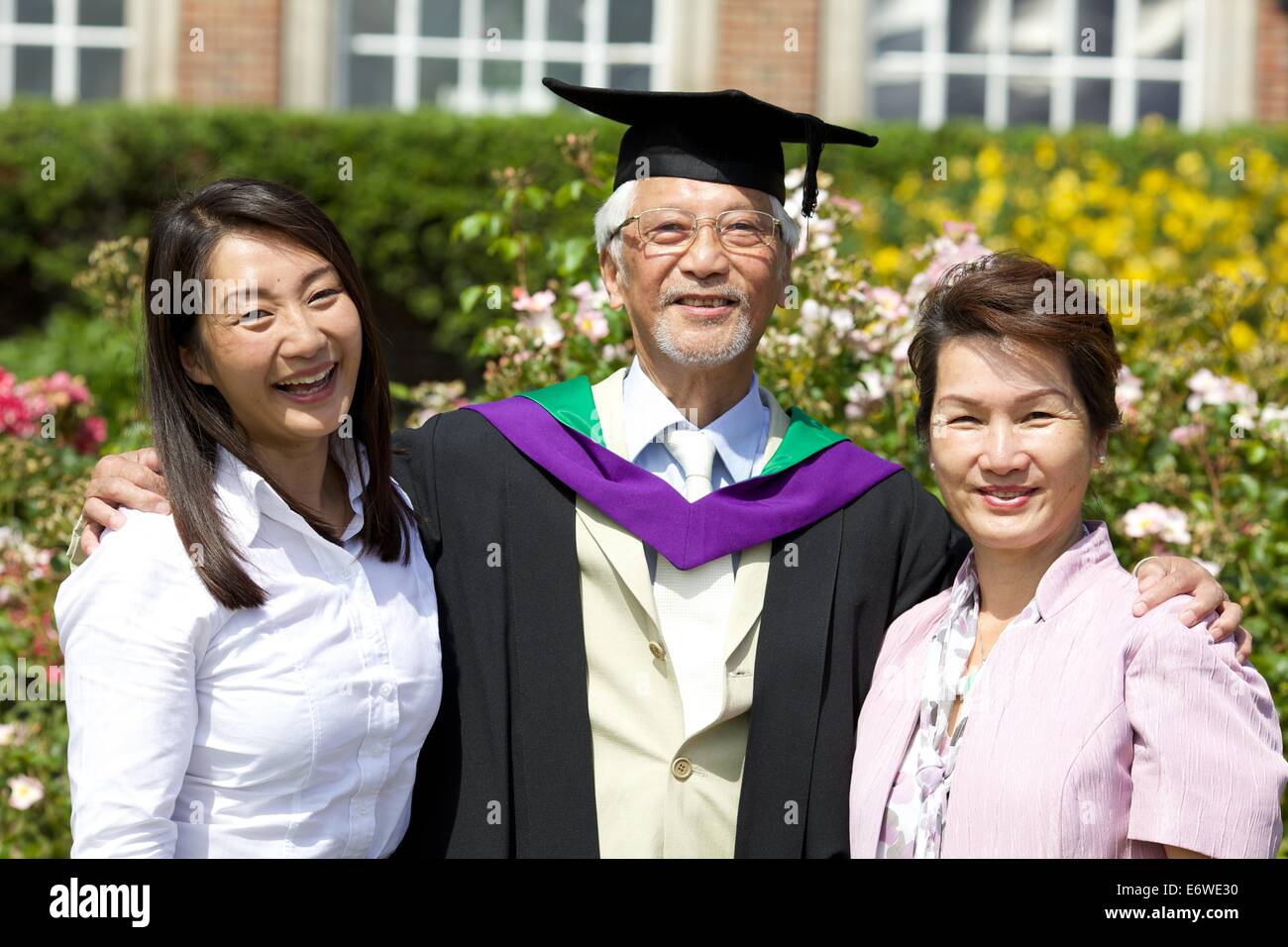 young asian female student at graduation ceremony with her parents ...