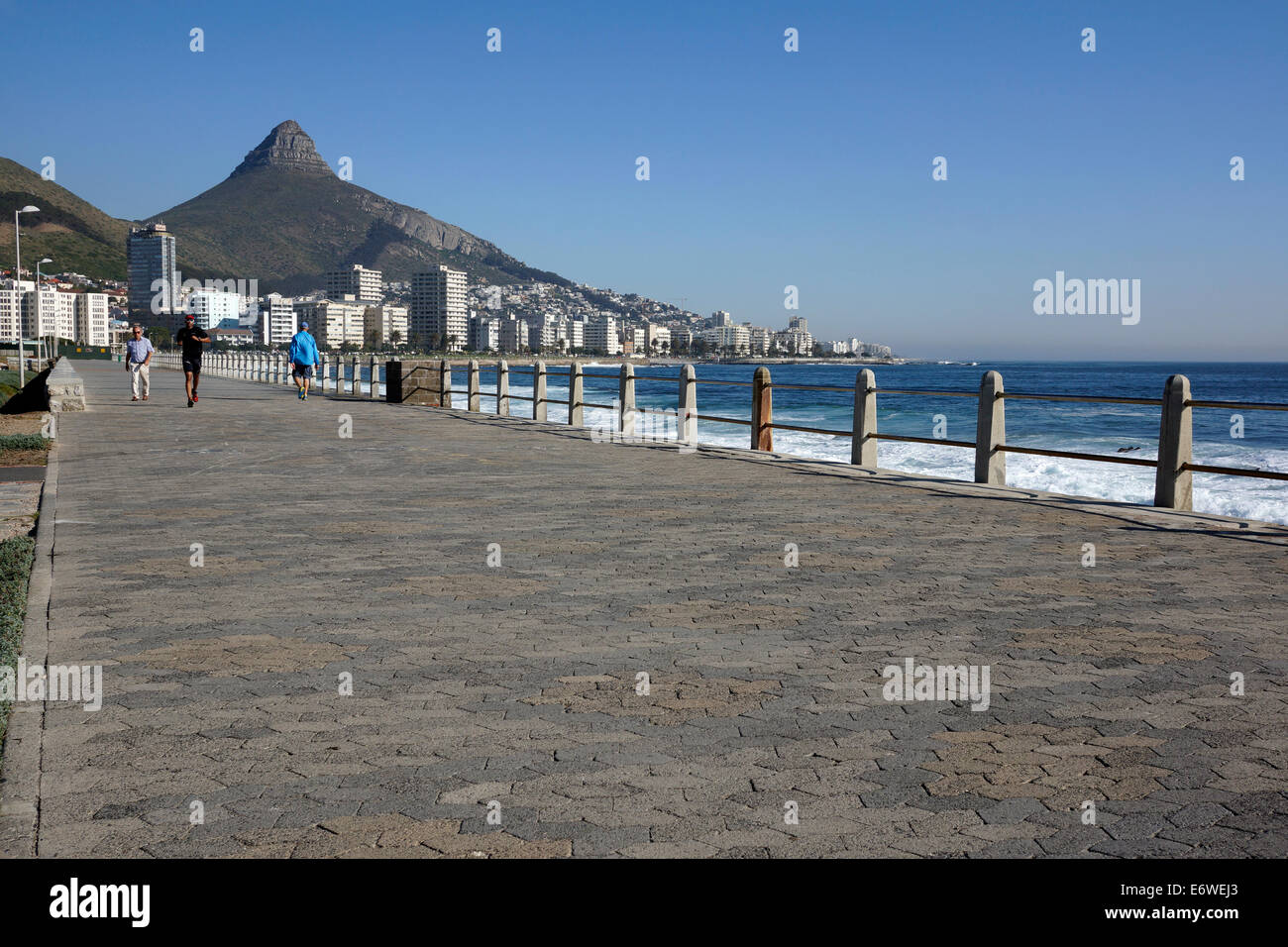People walking and jogging along the Sea Point promenade near Cape Town ...