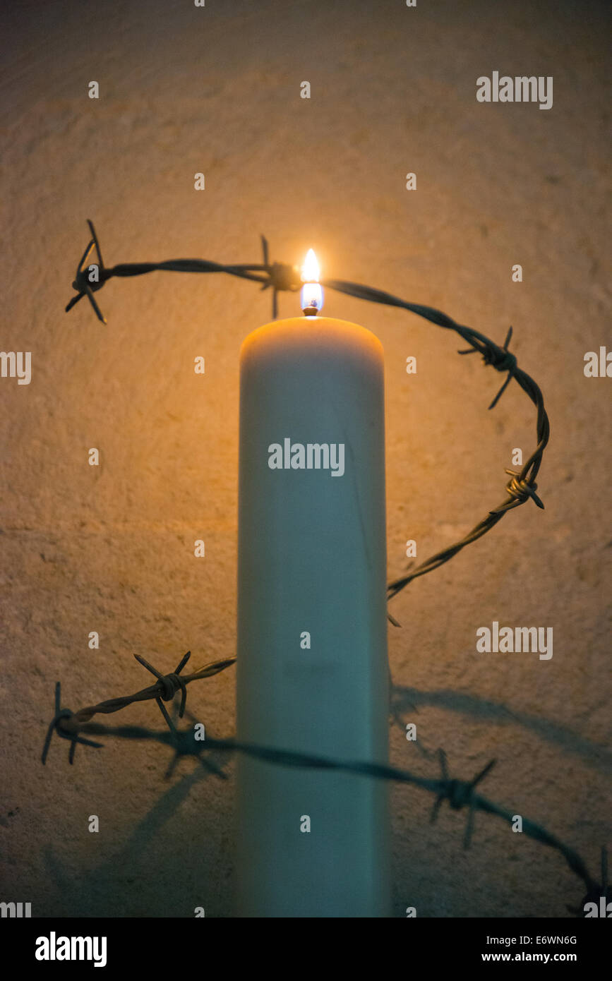 Candle burning with barbed wire Stock Photo - Alamy