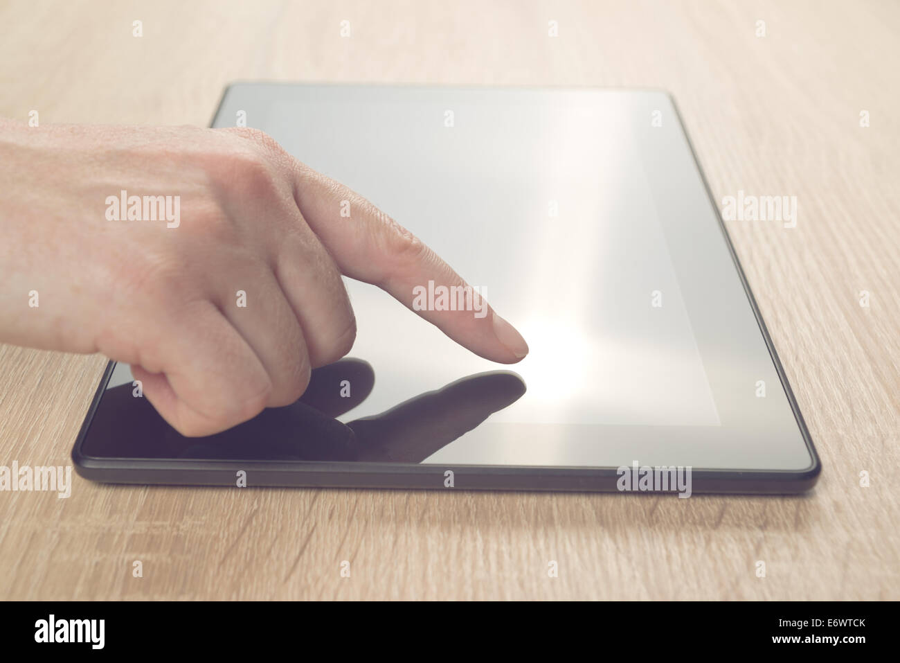 Female index finger pressing touch screen of digital tablet computer ...