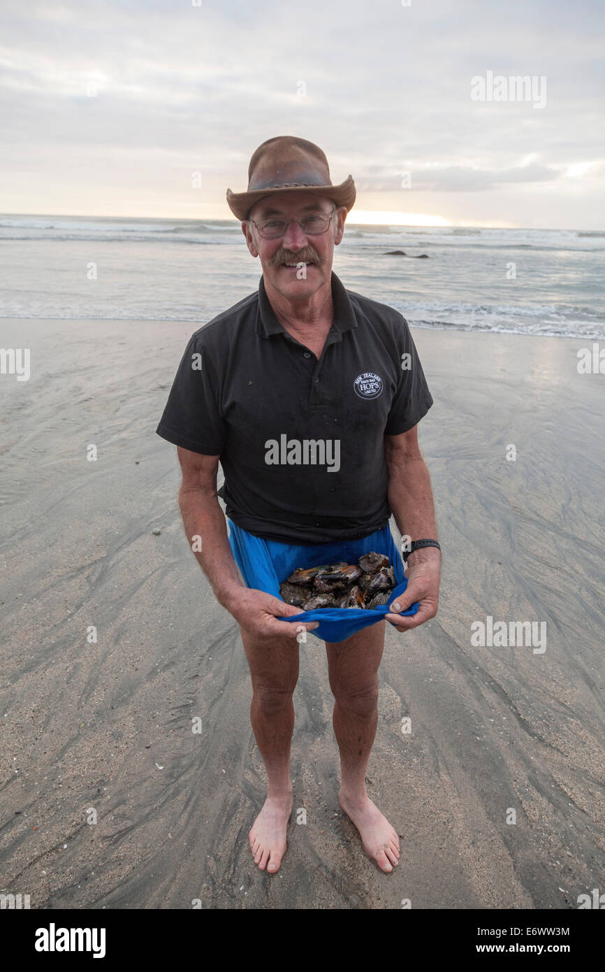 Man collecting mussels, Karamea, West coast, South Island, New Zealand ...