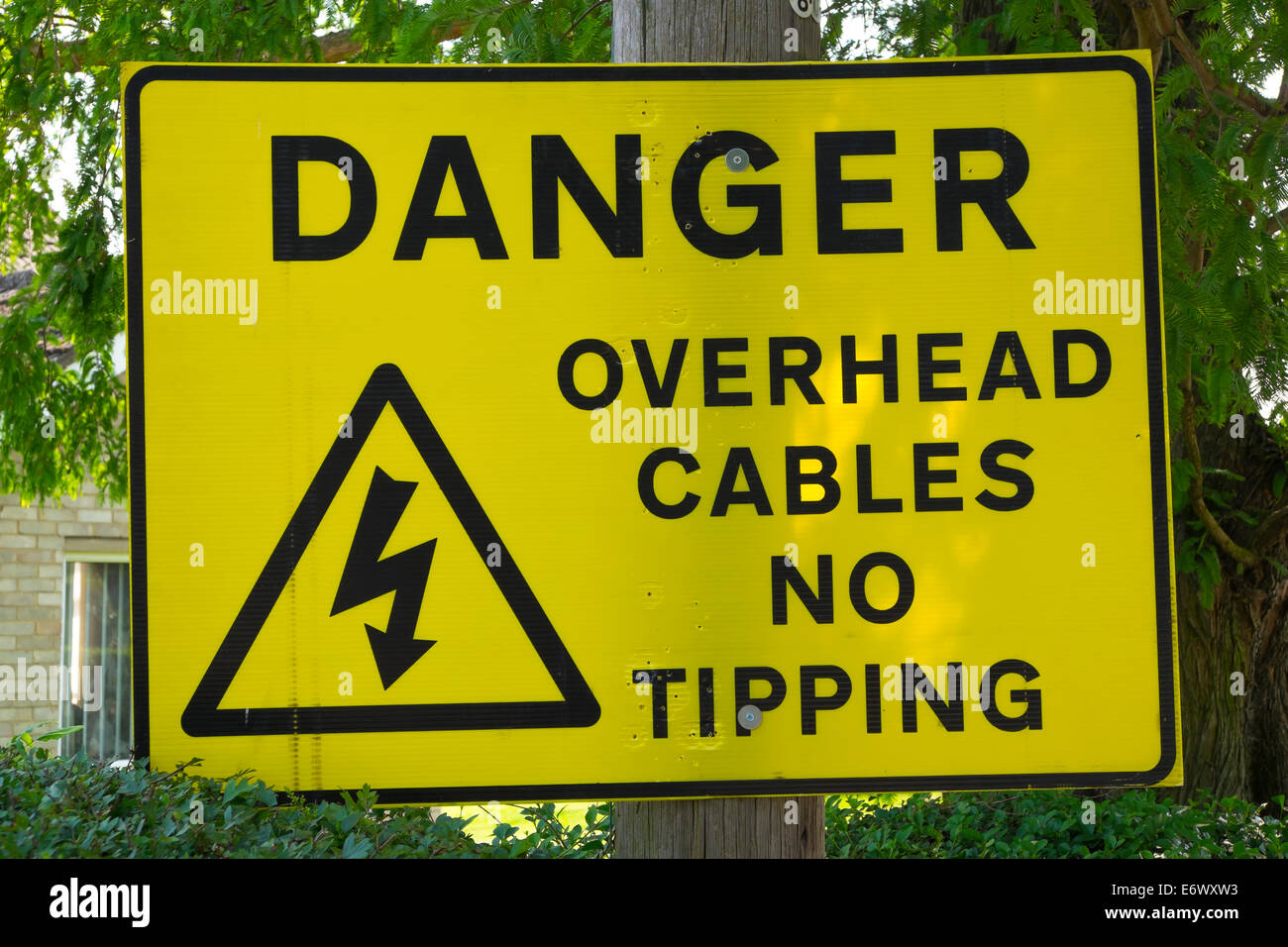 Danger Yellow road sign warning chippings tipper lorry of overhead ...