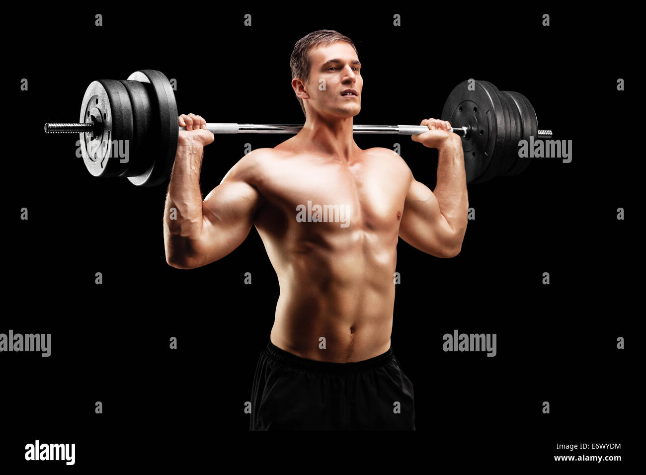 Weightlifting athlete lifting a barbell on black background Stock Photo ...