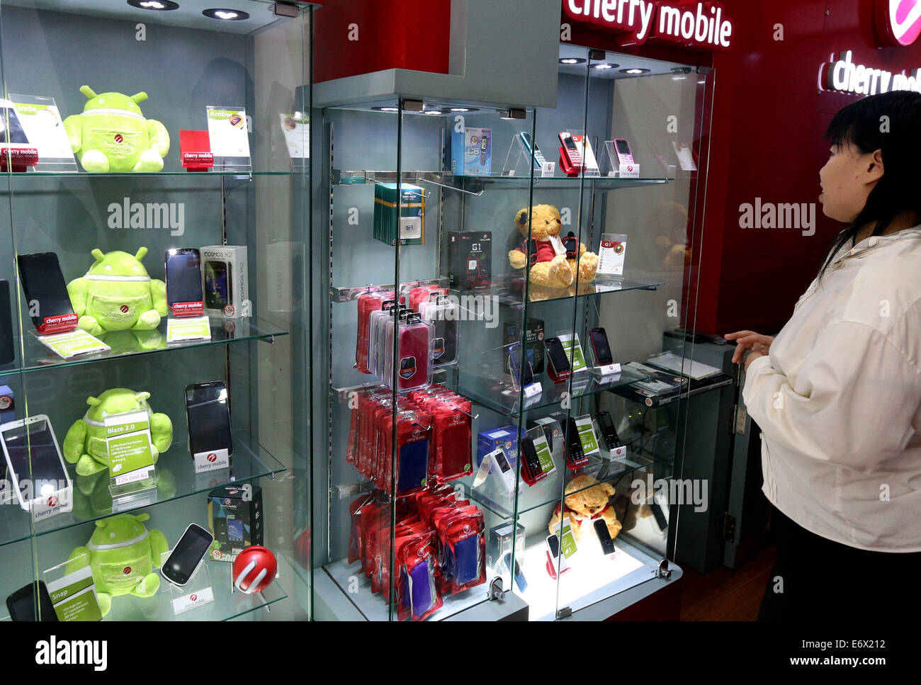 Yangon. 1st Sept, 2014. A customer looks at mobile phones at a mobile ...