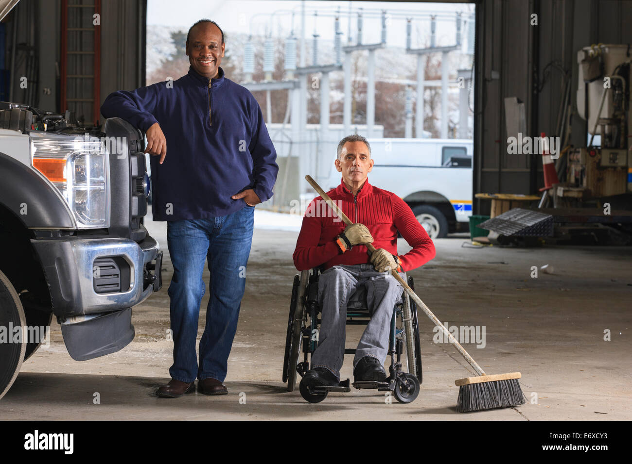 Maintenance technicians cleaning in utility truck garage at Electric ...