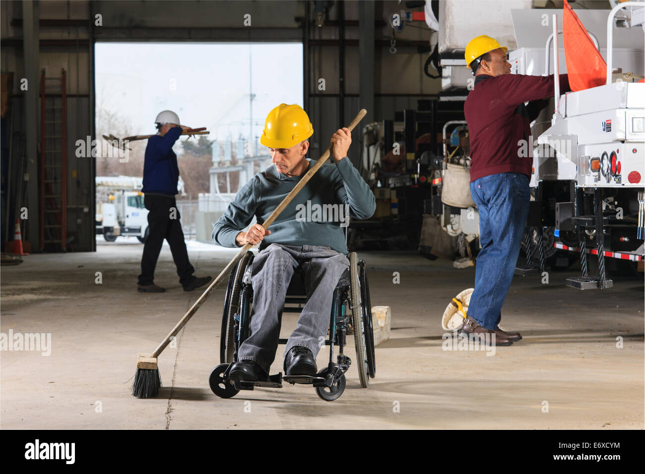 Maintenance technicians cleaning in utility truck garage at electric ...