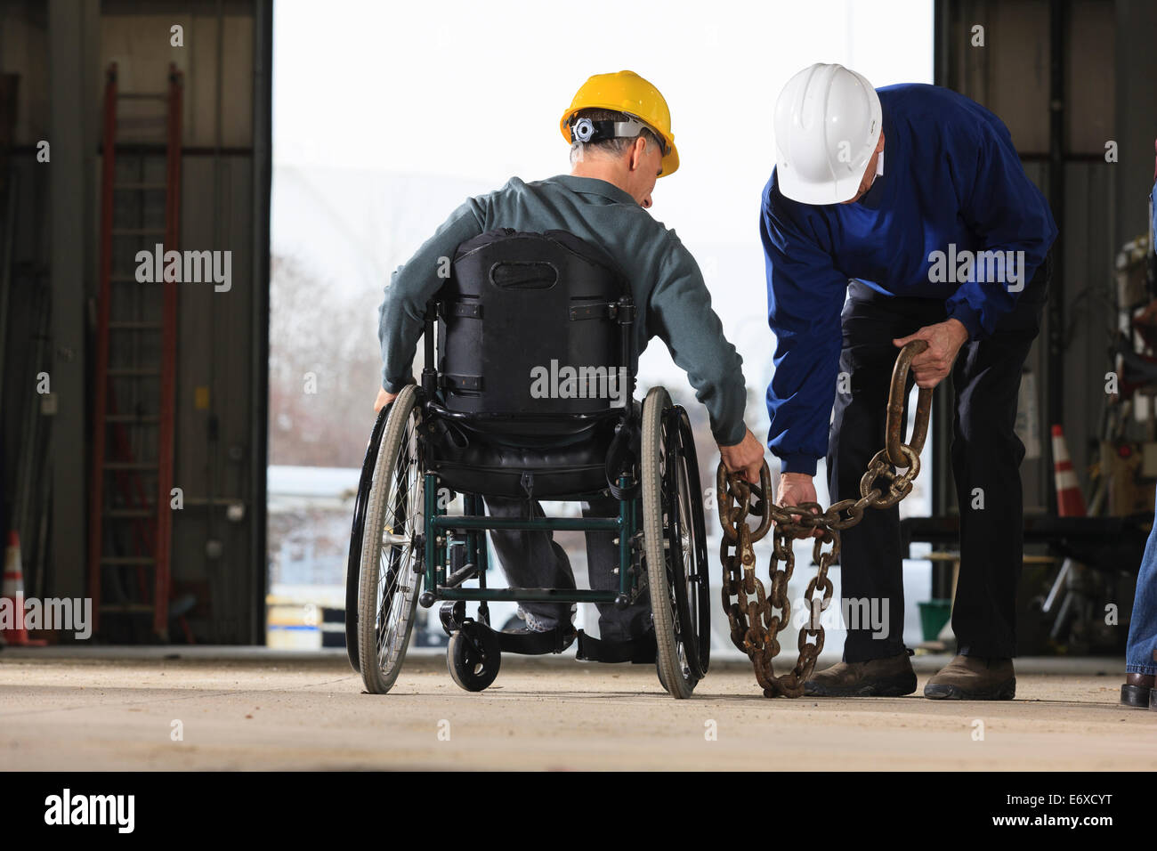 Maintenance supervisors one with spinal cord injury moving tow chain in ...
