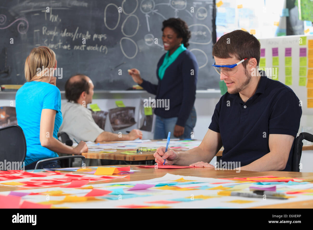 Engineering instructor working on flowchart on blackboard while ...