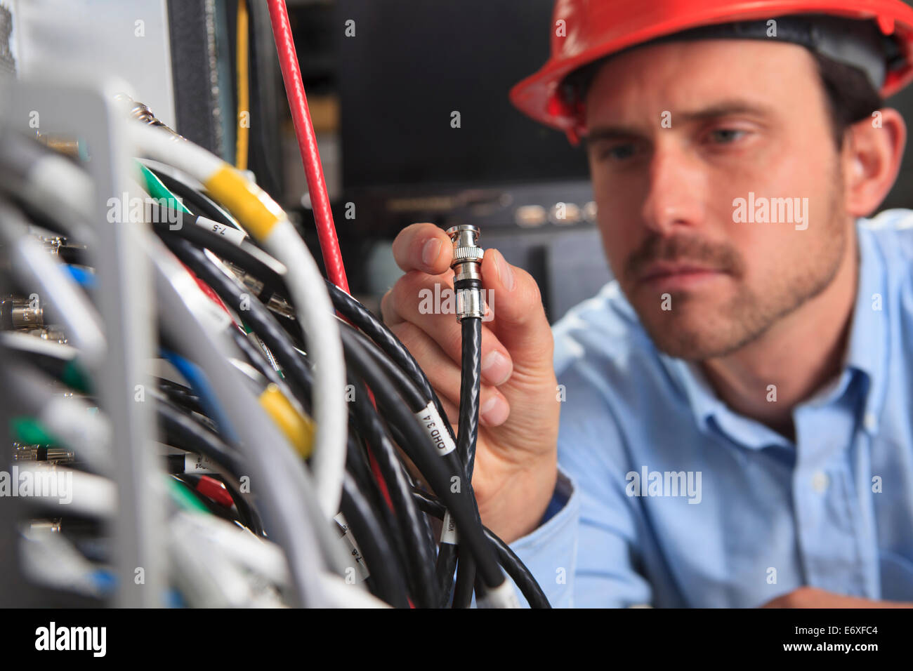 Network engineer holding BNC cable connection at patch panel Stock ...