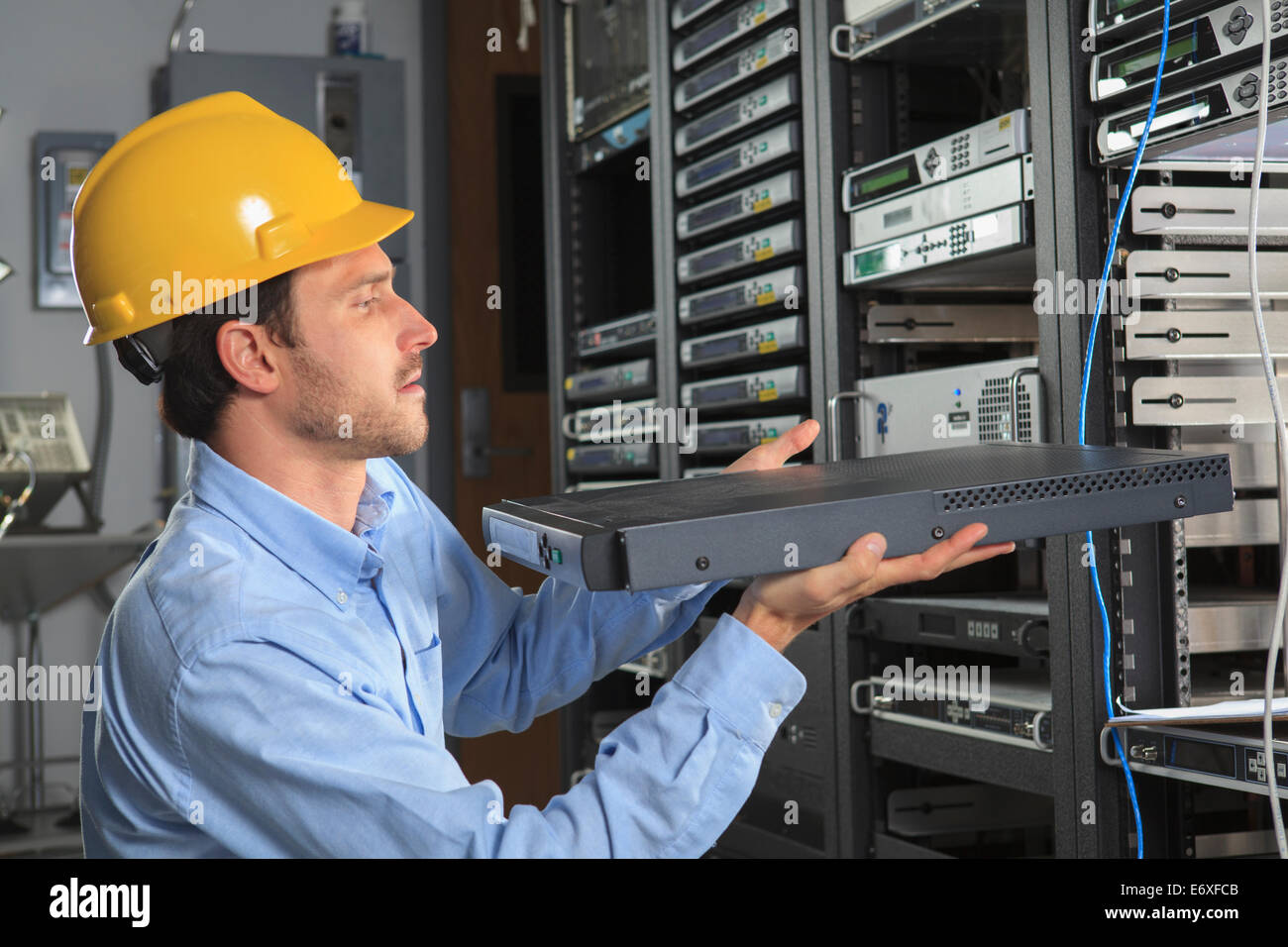 Network engineer installing cable equipment in rack Stock Photo - Alamy