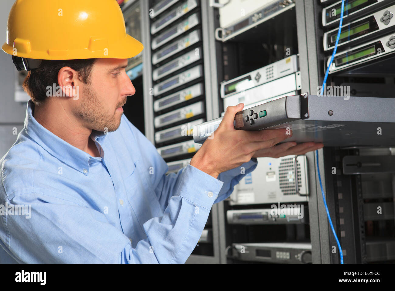 Network engineer installing cable equipment in rack Stock Photo - Alamy