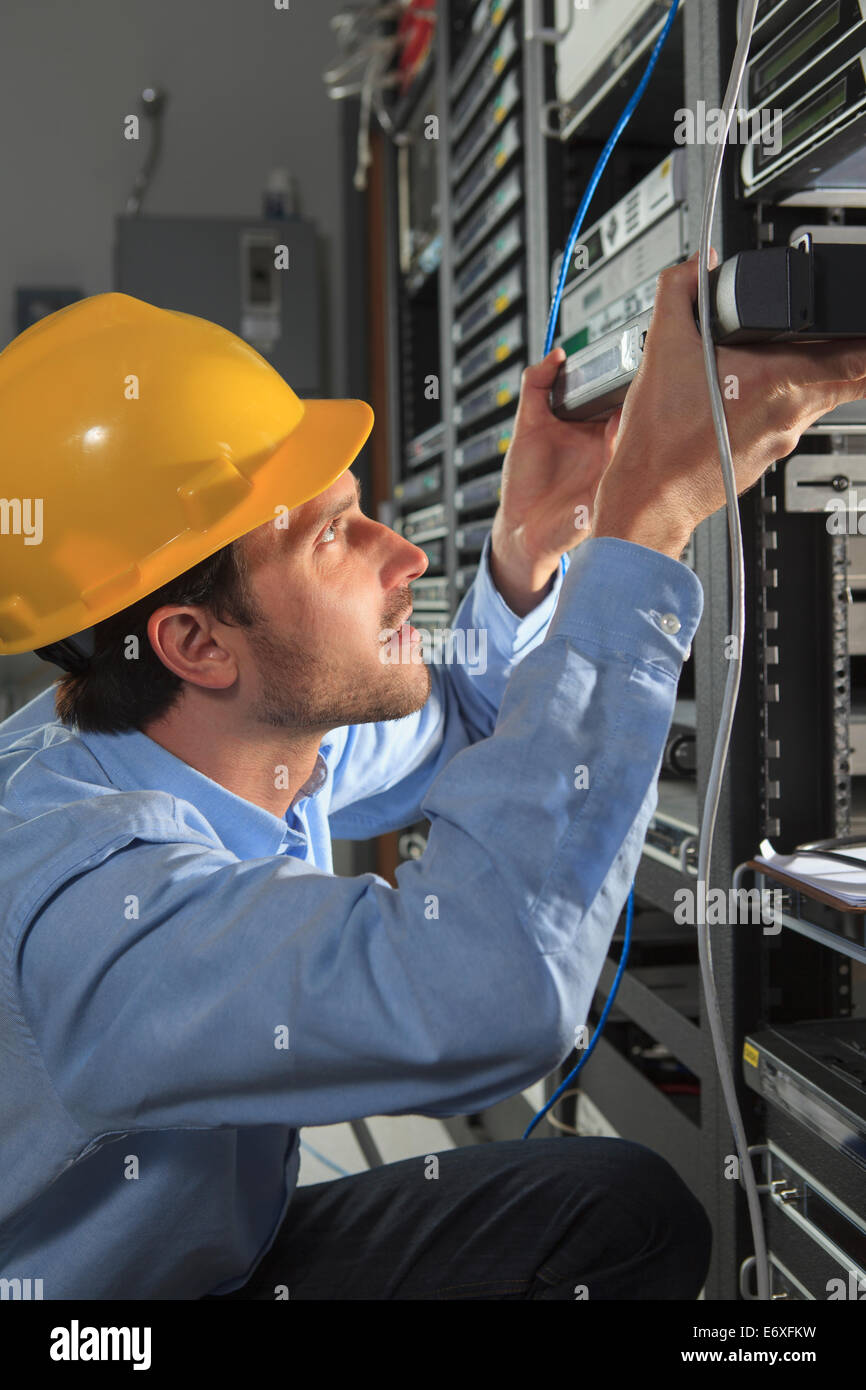 Network engineer installing cable equipment in rack Stock Photo - Alamy