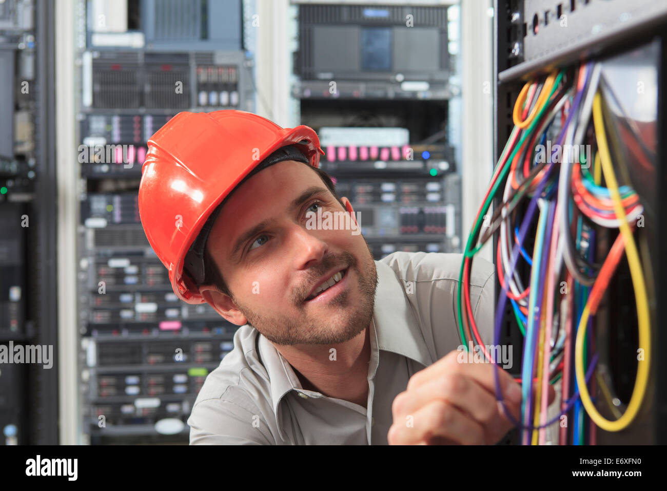Network engineer examining unstructured cable in data center Stock ...