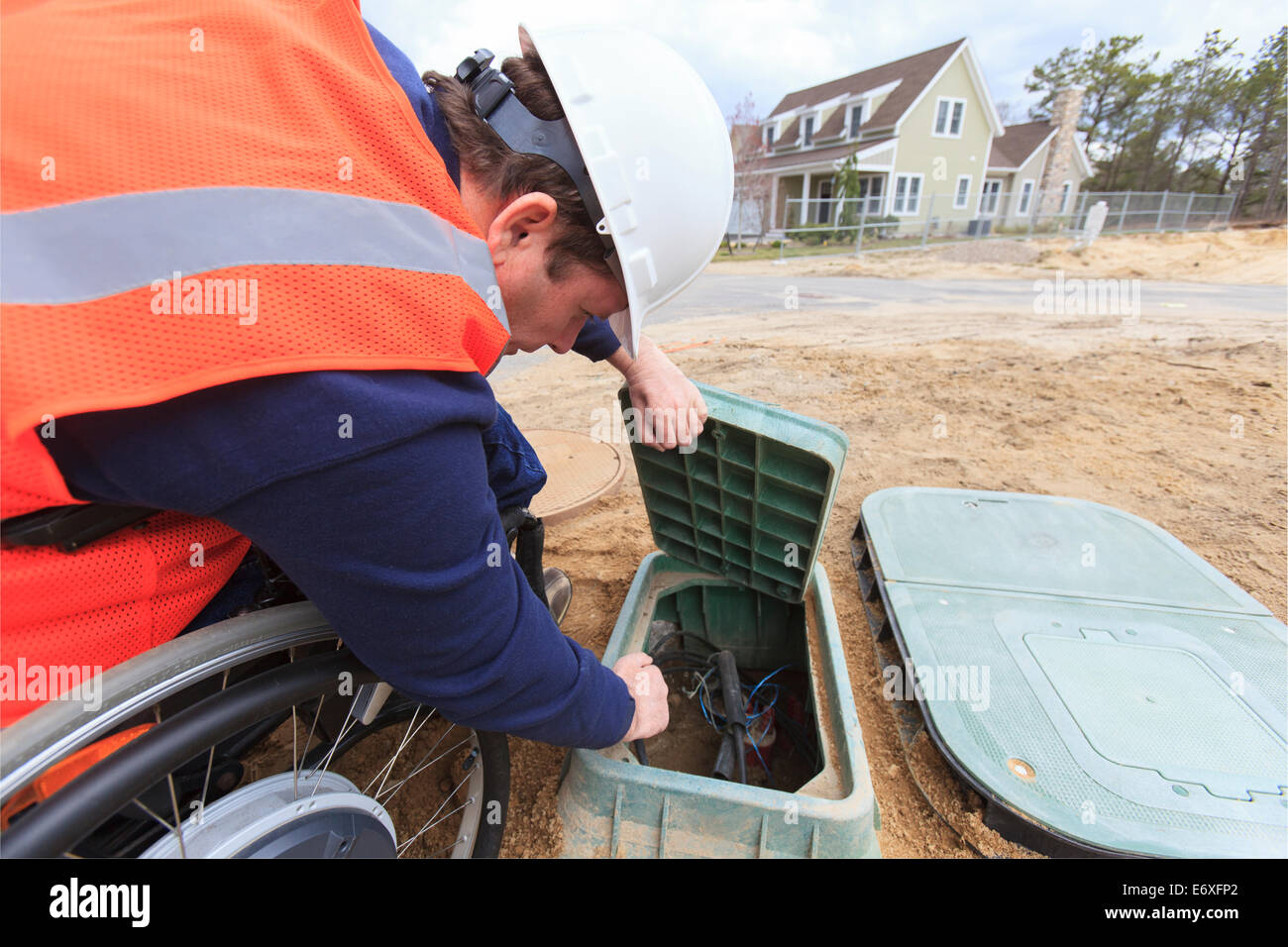 Construction engineer with spinal cord injury inspecting utility box ...
