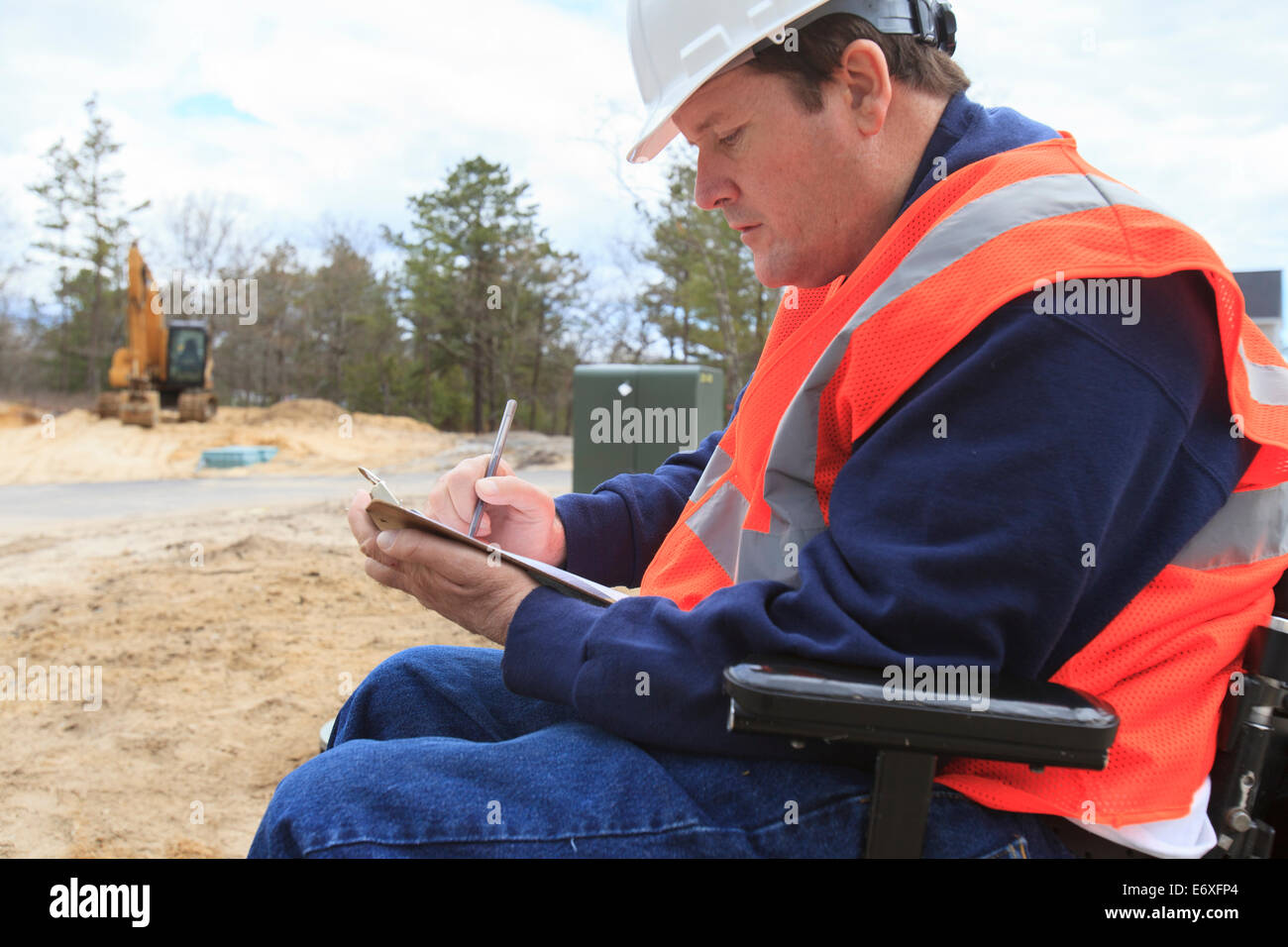 Construction engineer with spinal cord injury making notes at the site ...