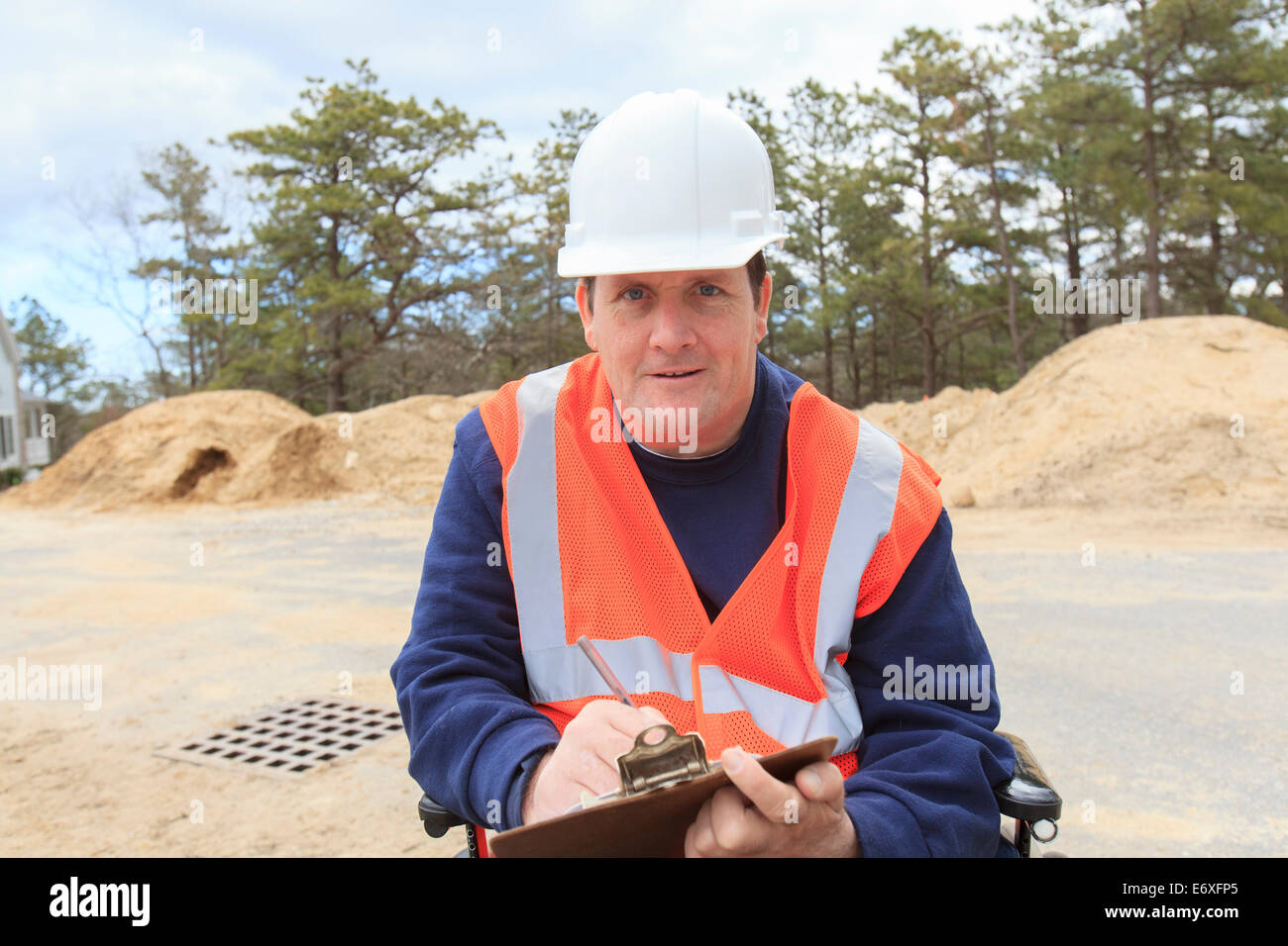 Construction engineer with spinal cord injury making notes at the site ...