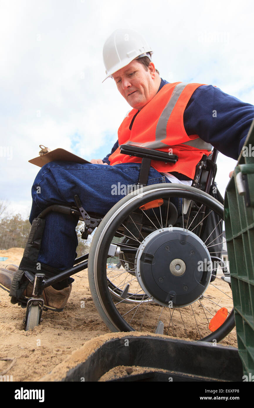 Construction engineer with spinal cord injury inspecting utility box ...